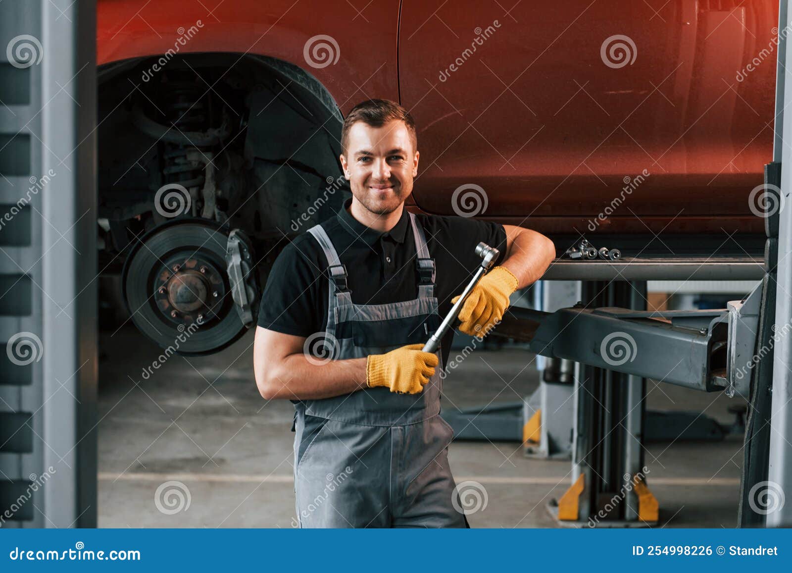 Professional Service. Man in Uniform is Working in the Auto Service ...