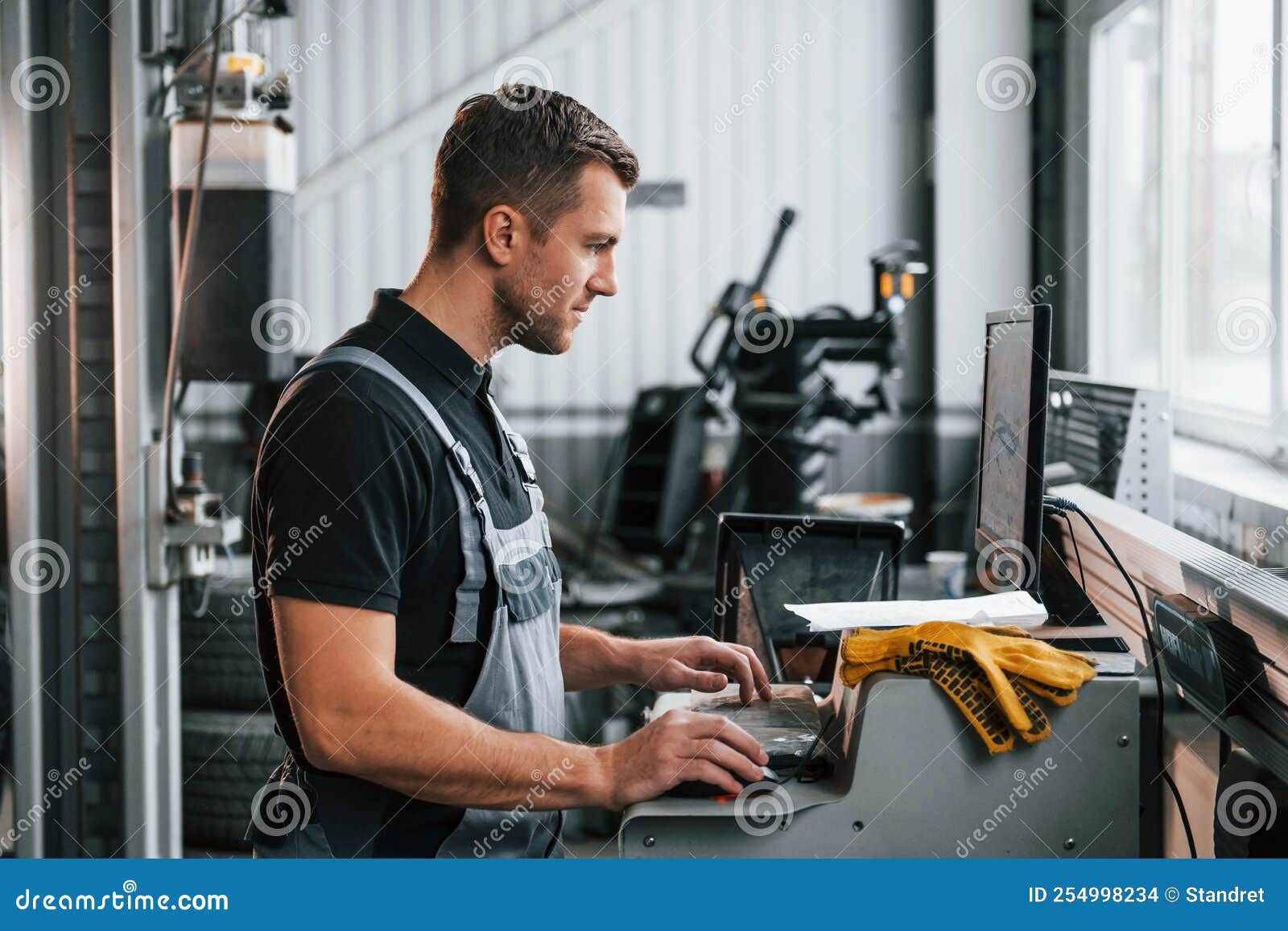 Professional Service. Man in Uniform is Working in the Auto Service ...