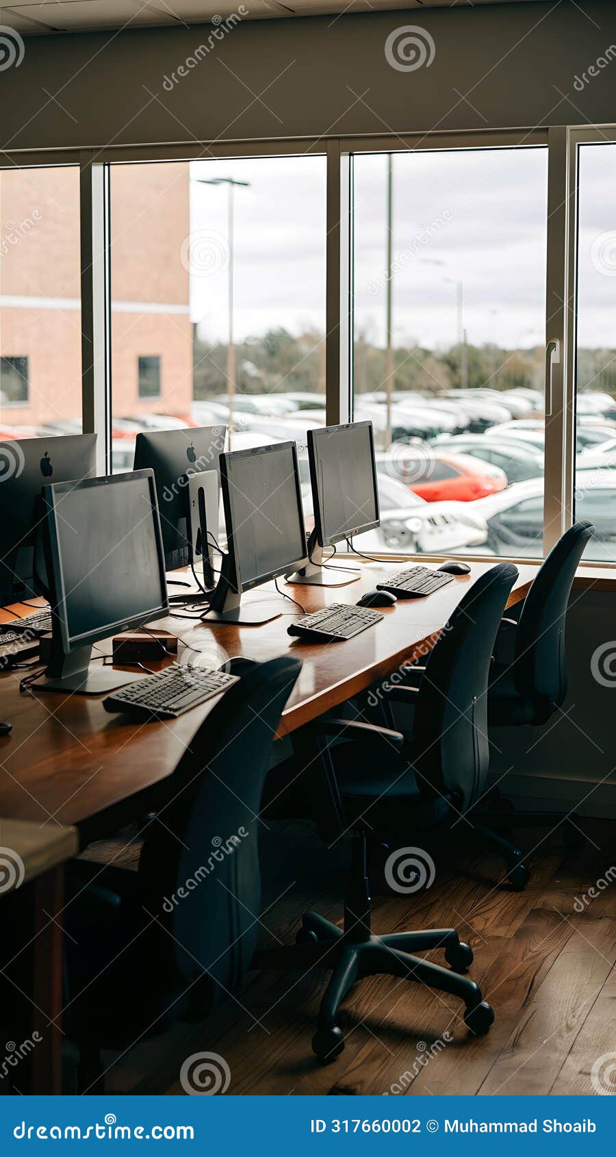 Professional, Spacious Office Setup with Three Monitors, Keyboards, Mice, and Large Windows ...