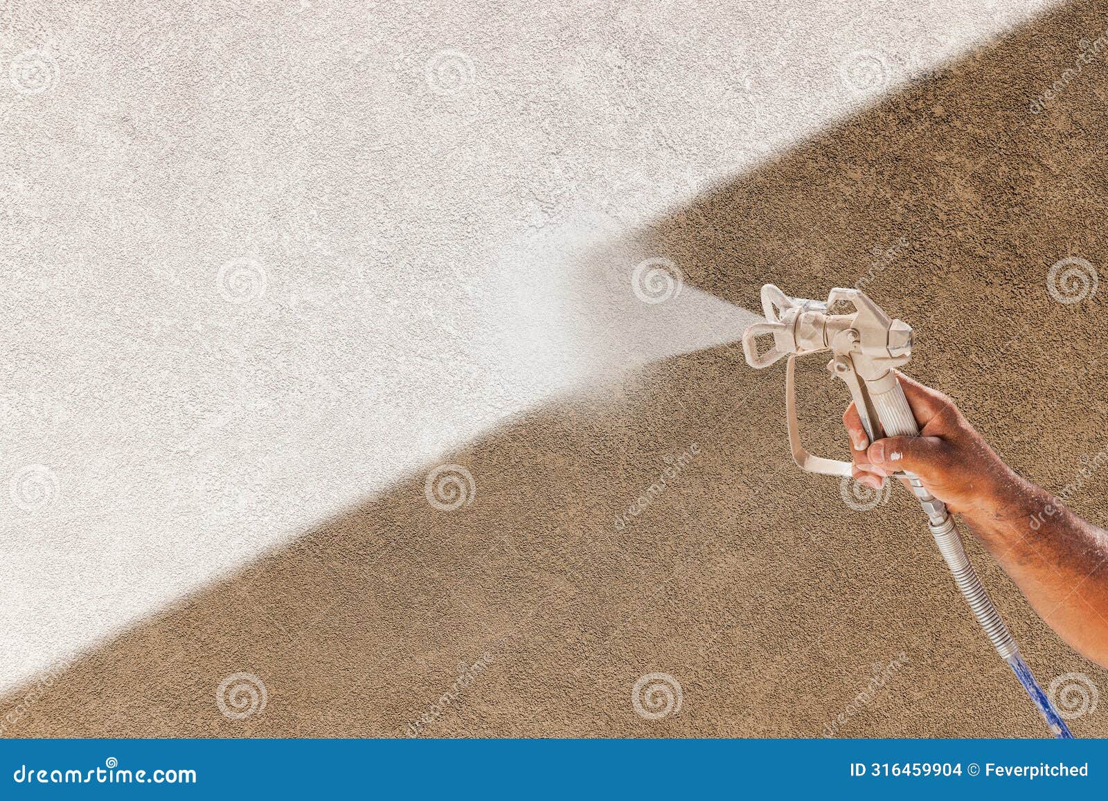 Spray Painter Holding Spray Gun Spraying White Paint Over Brown Stucco ...