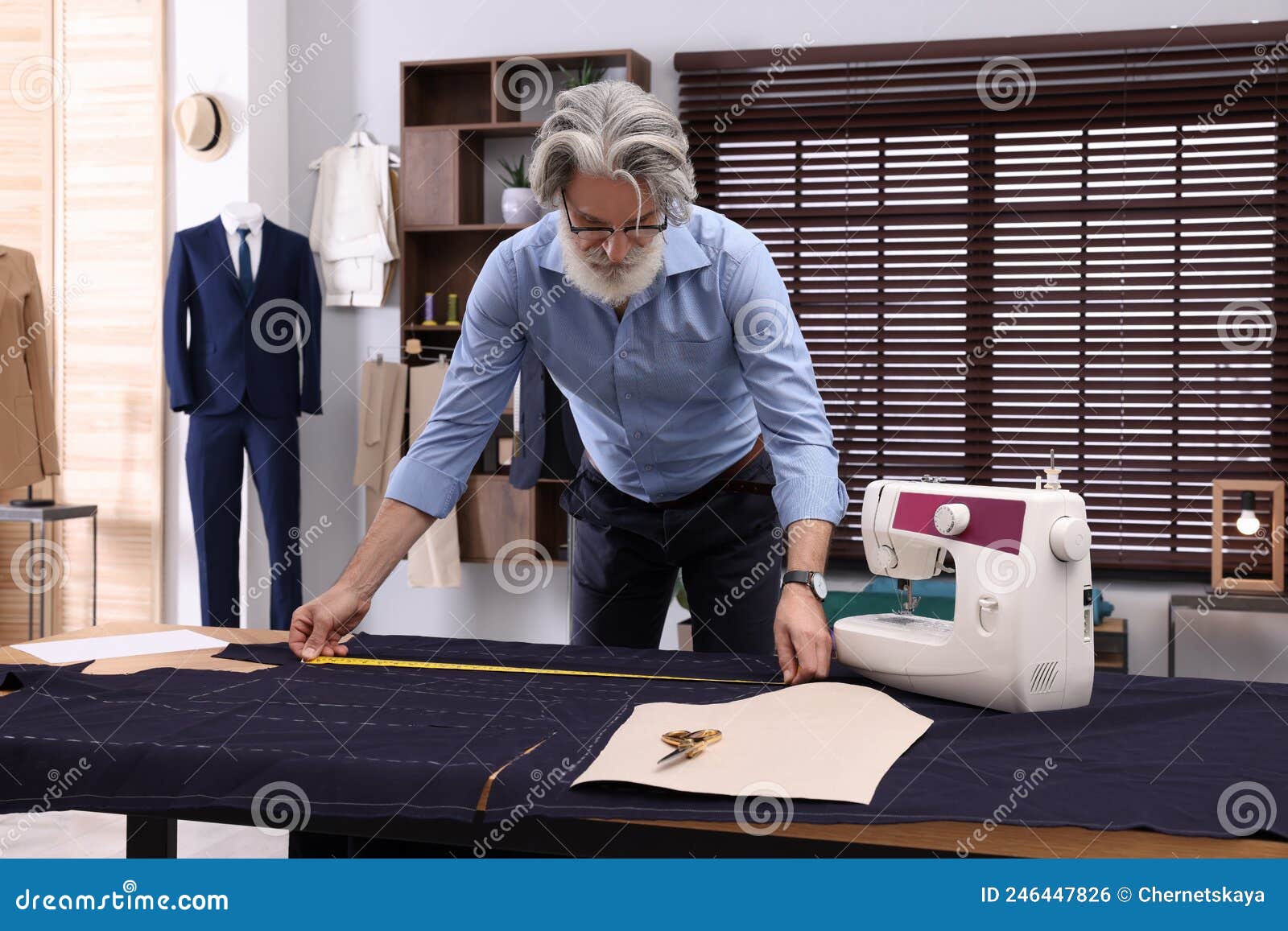 Professional Tailor with Measuring Tape Working at Table in Atelier ...