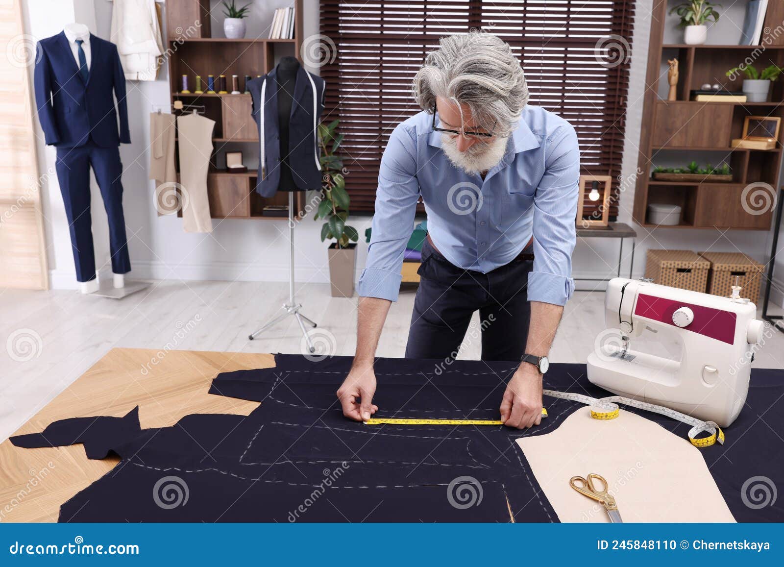 Professional Tailor with Measuring Tape Working at Table in Atelier ...