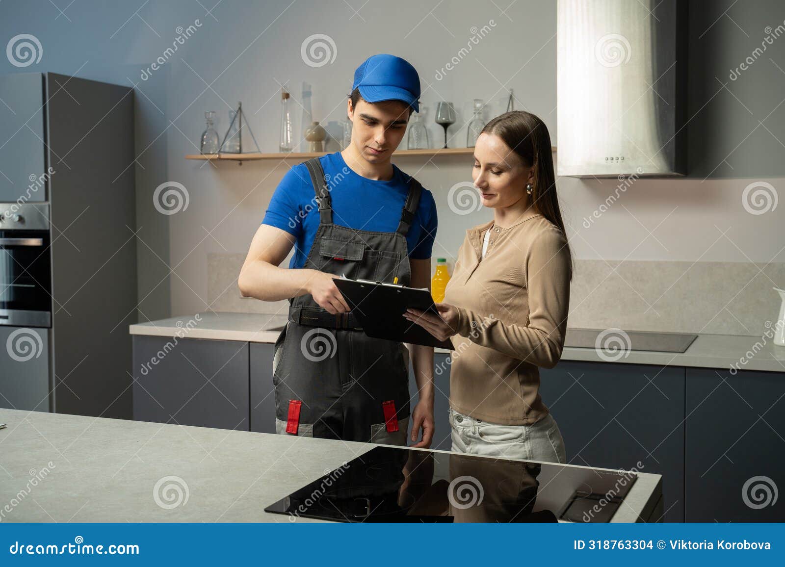 Professional Technician Consults with Homeowner in Modern Kitchen ...