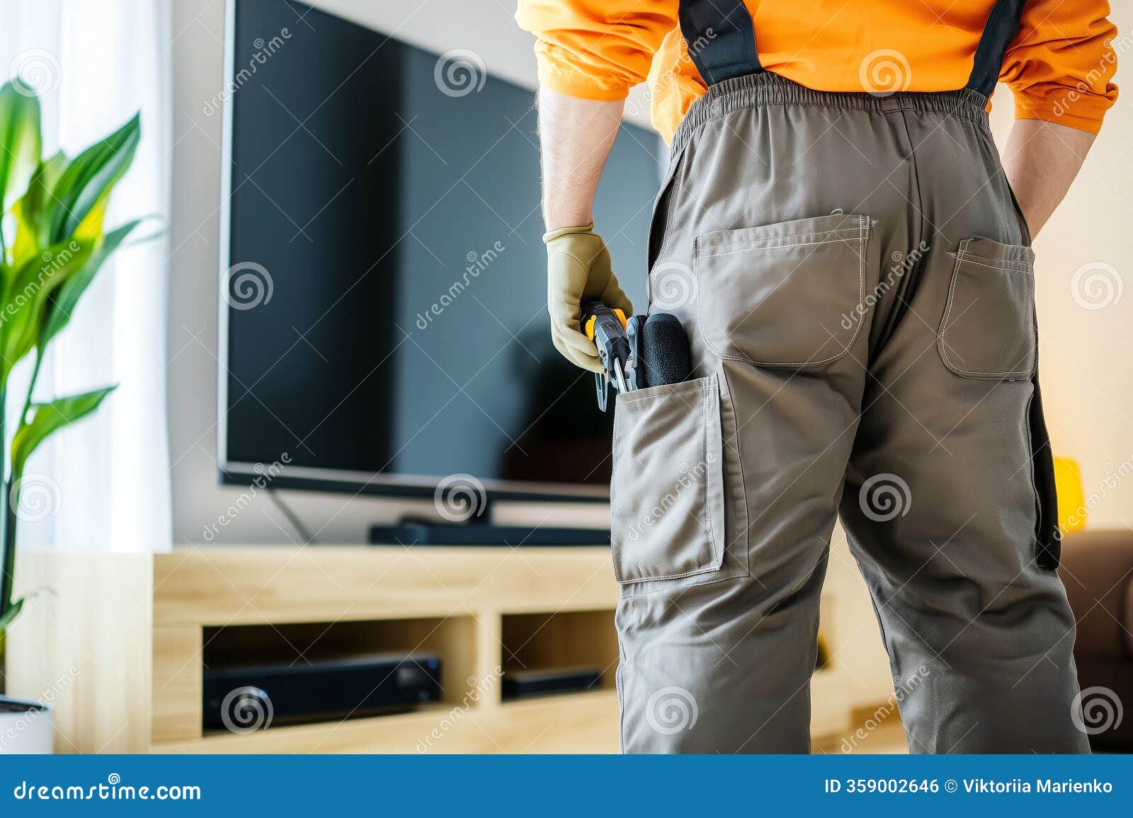 Professional Technician Fixing a Flat-screen TV in the Living Room with ...