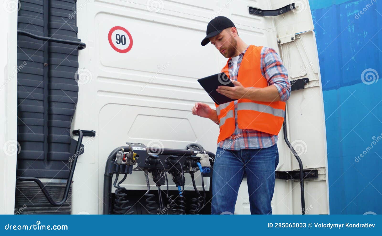 Professional Truck Driver Checking Using Tablet Computer and Standing ...