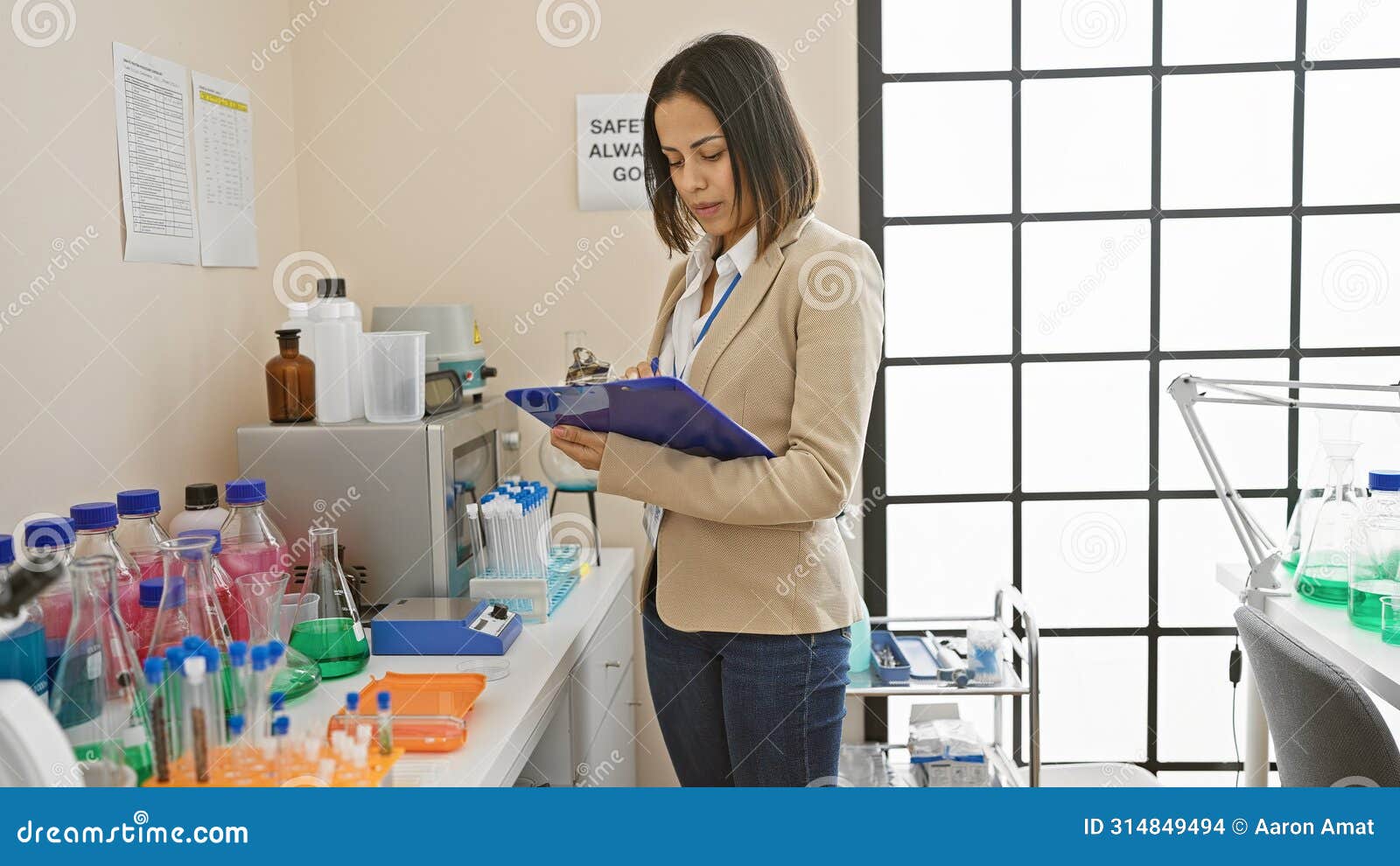 Professional Woman Reviewing Documents in a Modern Laboratory Setting ...