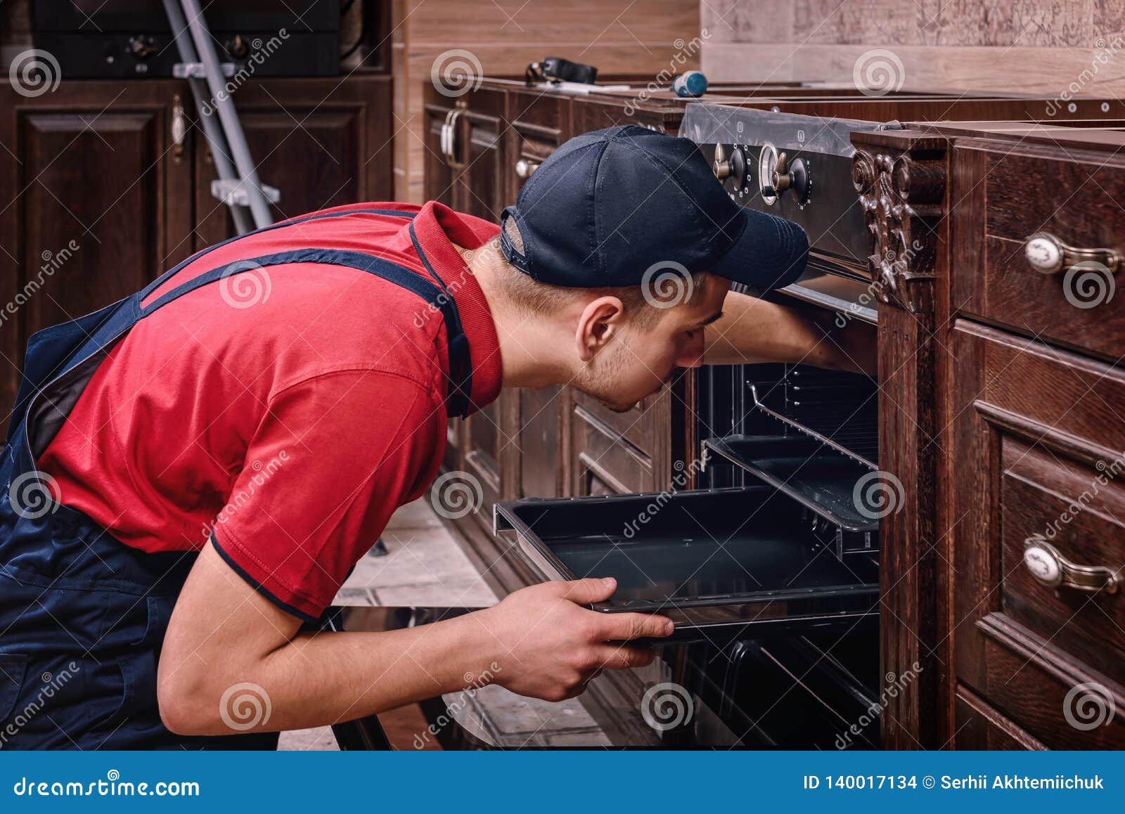 Professional Worker Assembling Oven. Installation of Kitchen Furniture ...