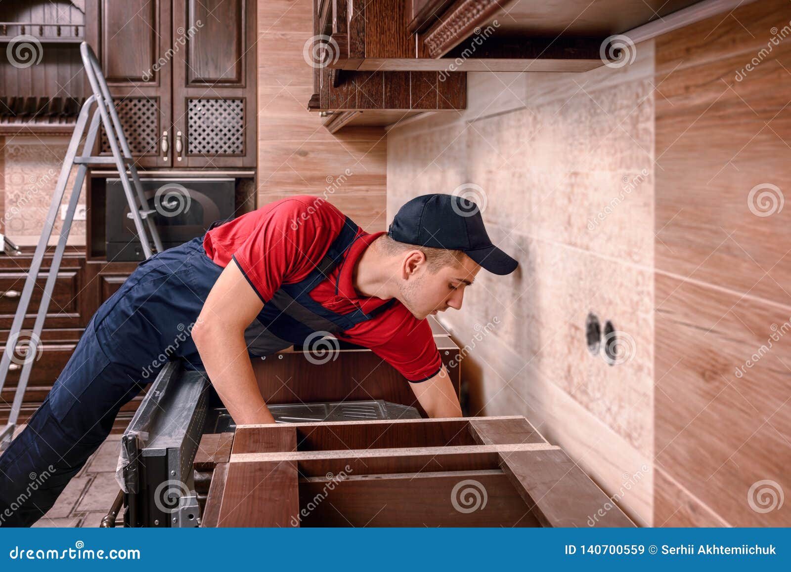 Professional Worker Assembling Oven. Installation of Kitchen Furniture ...