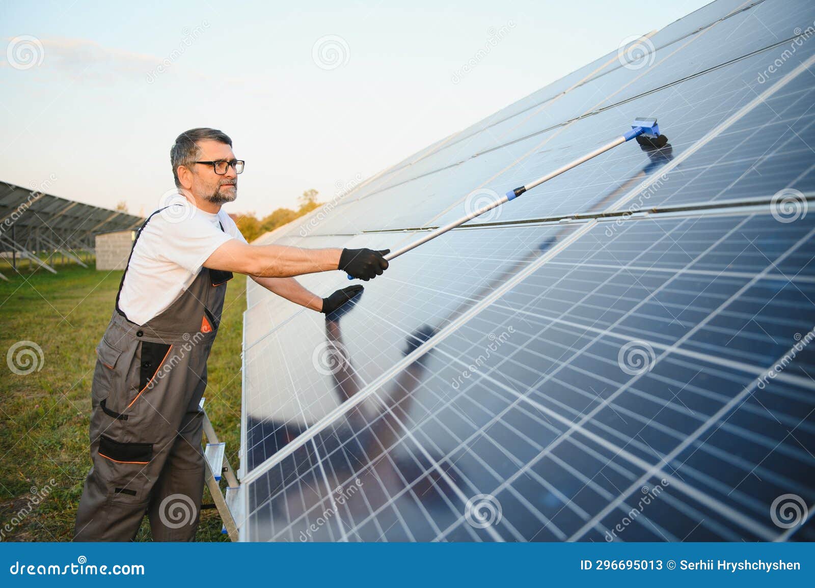 Professional Worker Cleaning Solar PV Panel. Man Making Sure Solar ...