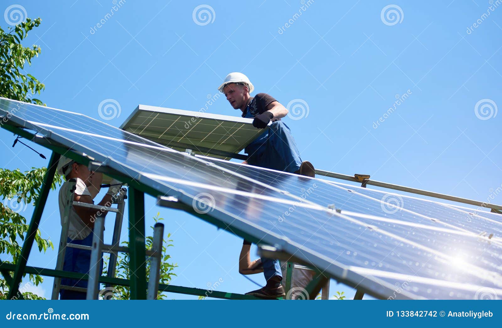 Professional Worker Installing Solar Panels on the Green Metal ...