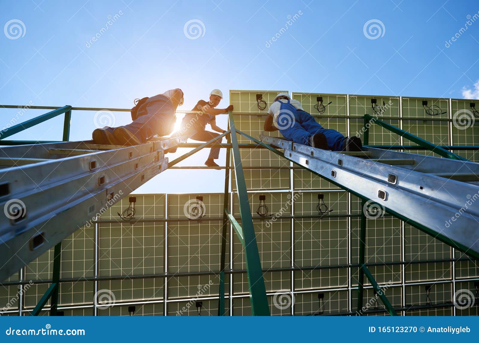 Professional Worker Installing Solar Panels on the Green Metal ...