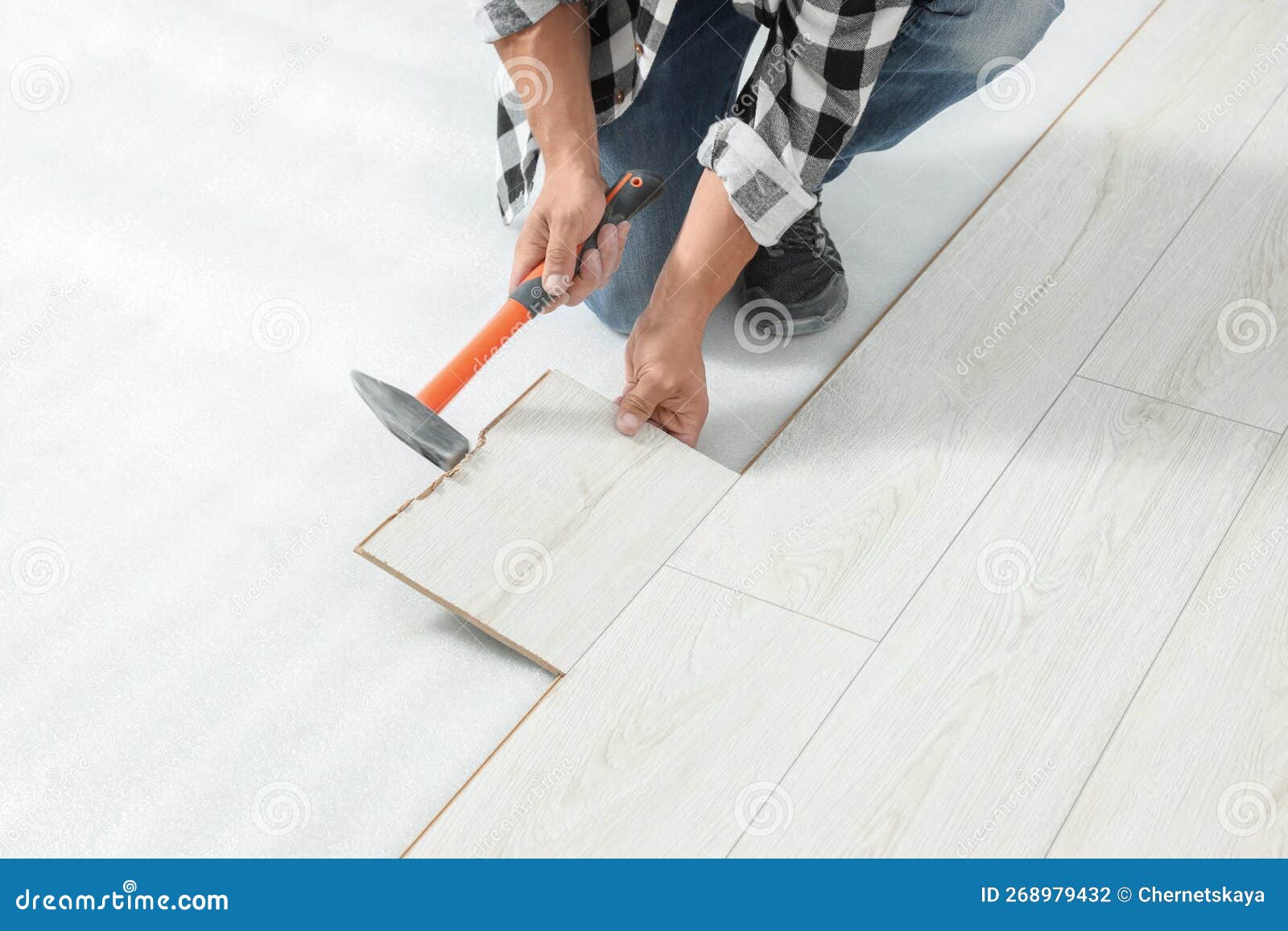 Professional Worker Using Hammer during Installation of New Laminate ...