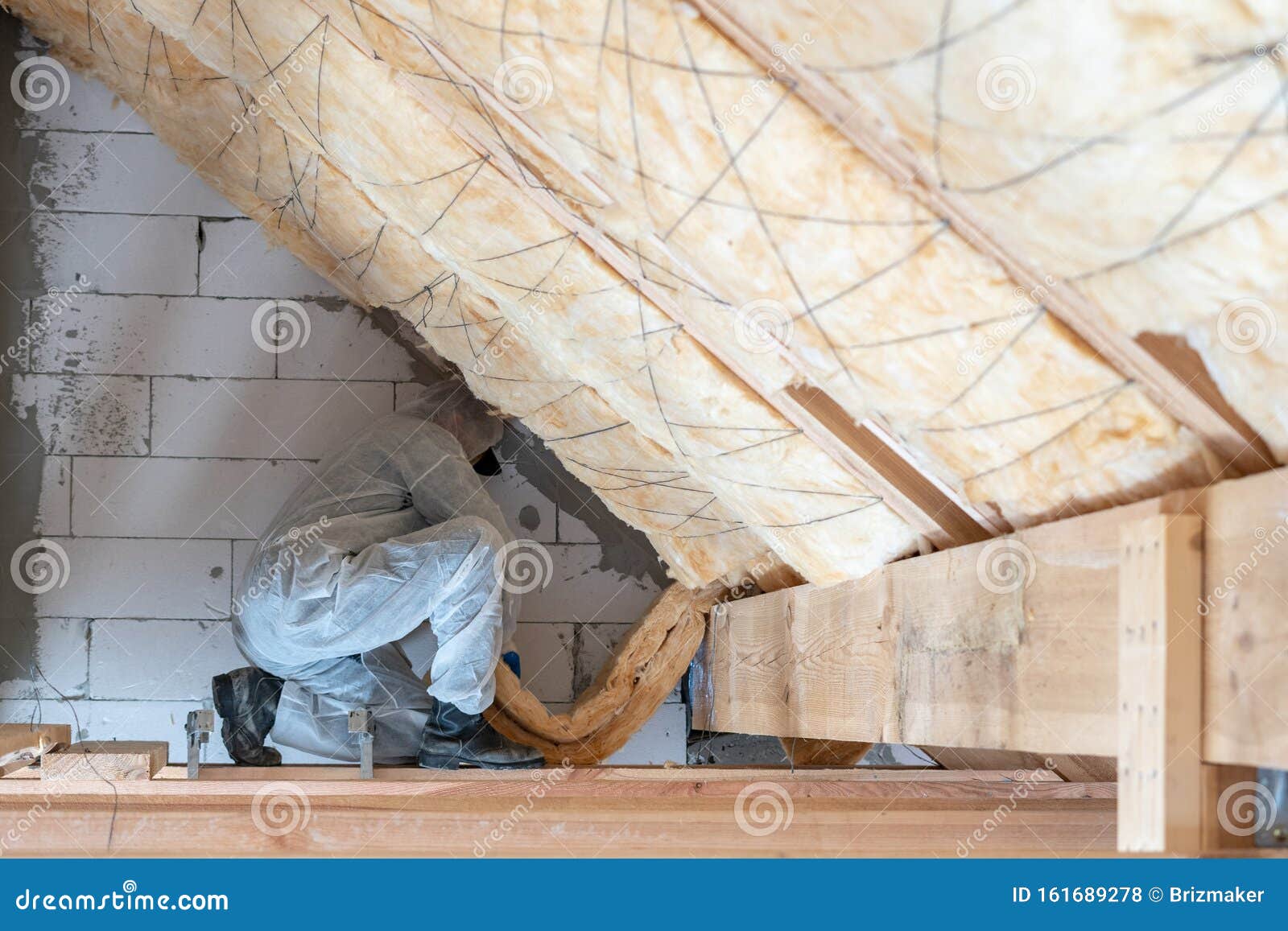 Professional Workman Installing Thermal Insulation Layer Under the Roof ...