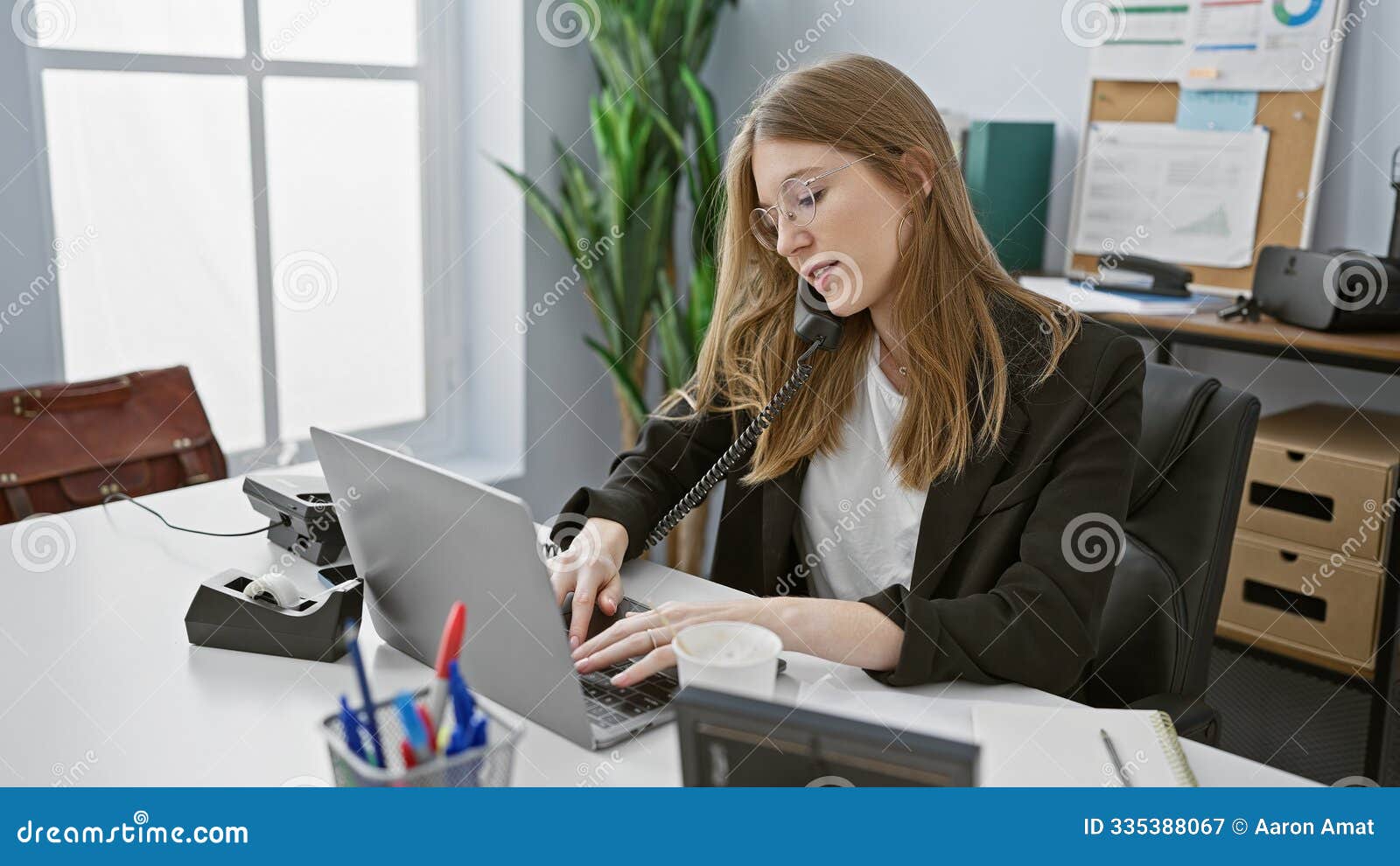A Professional Young Woman Multitasks in a Modern Office, Engaging with ...