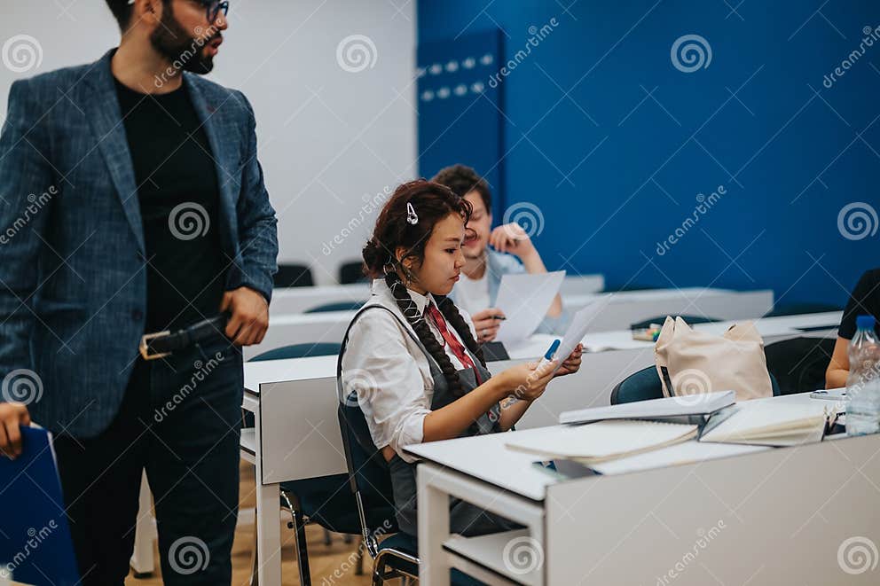 Professor Assists Students during a Classroom Task Session Stock Image ...