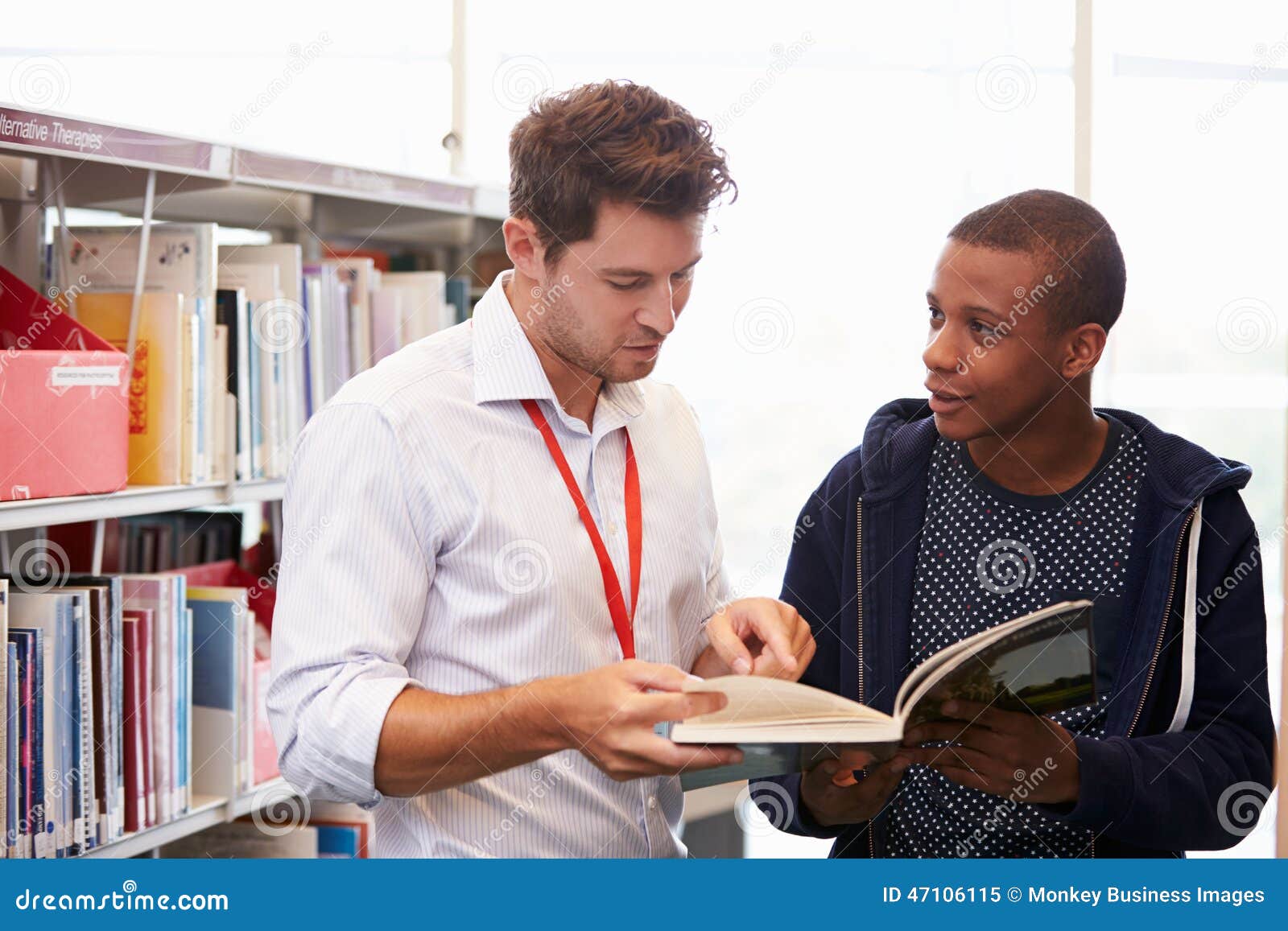 Professor Helping College Student Com Estudos Na Biblioteca Imagem de ...