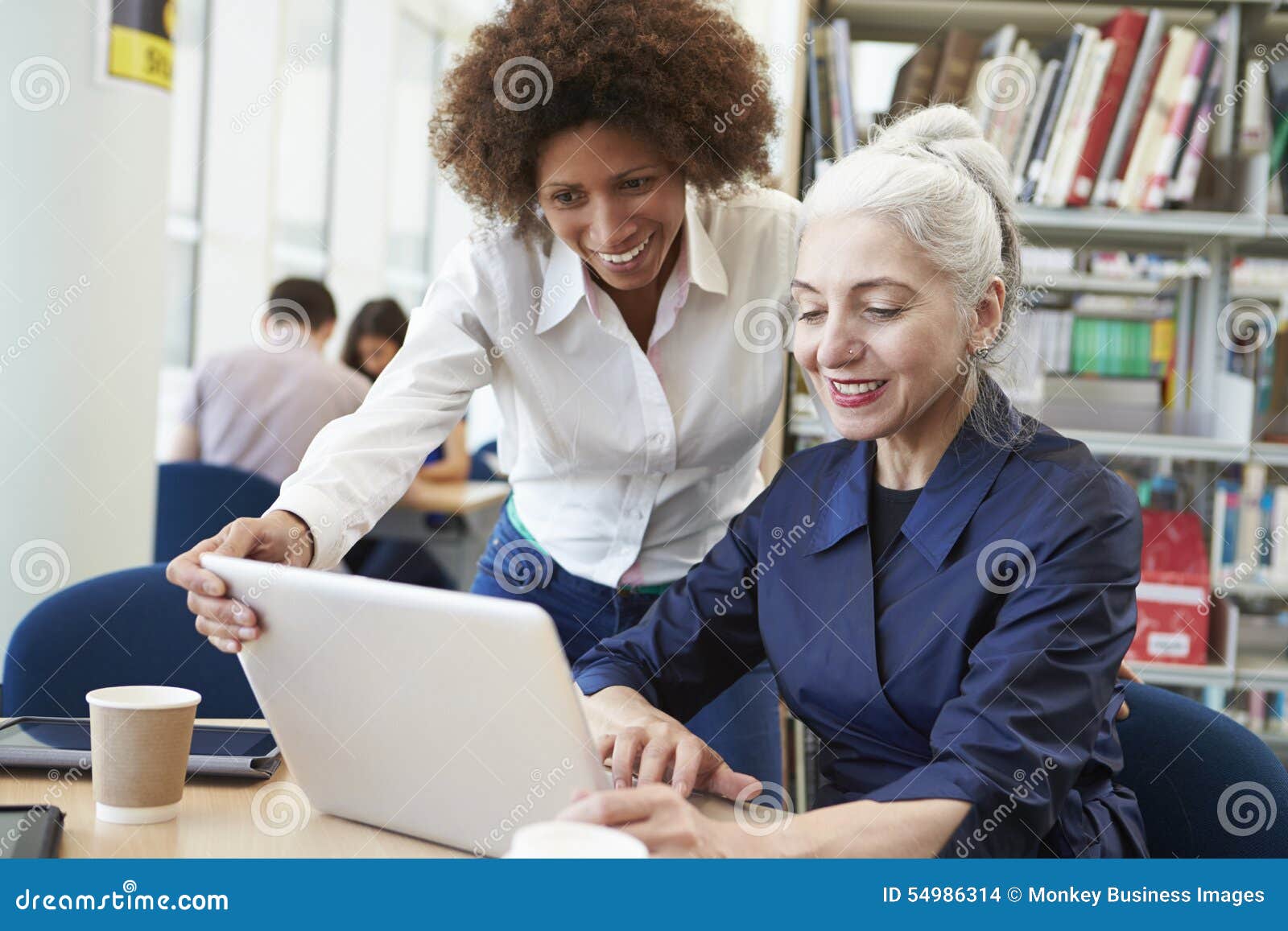 Professor Helping Mature Student Com Estudos Na Biblioteca Foto de ...