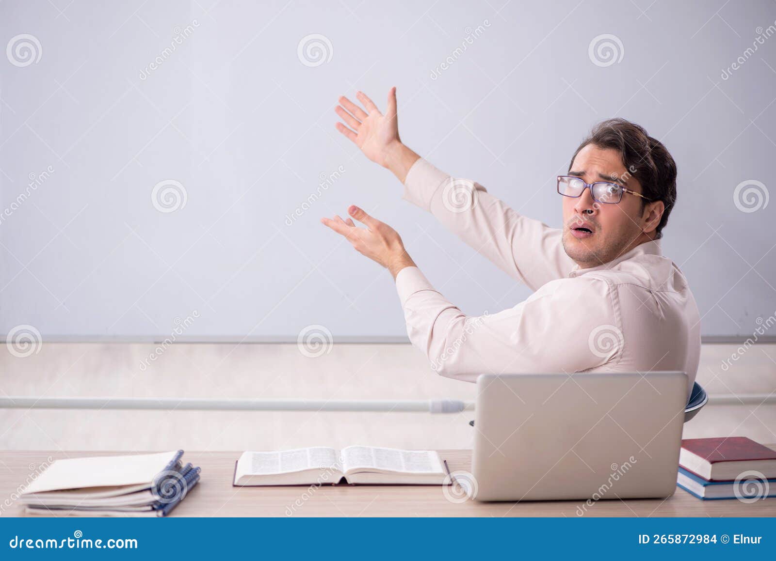 Professor Jovem Sentado Na Sala De Aula Foto de Stock - Imagem de ...