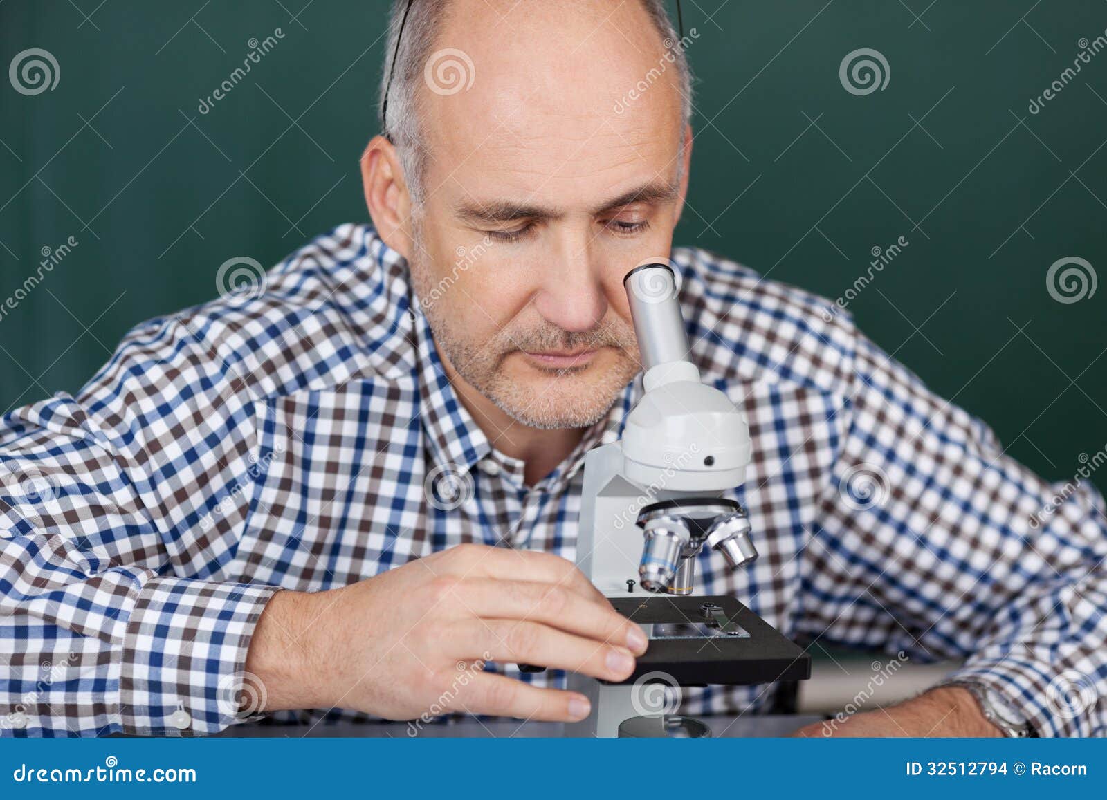 Professor Looking through Microscope in Science Class Stock Photo ...