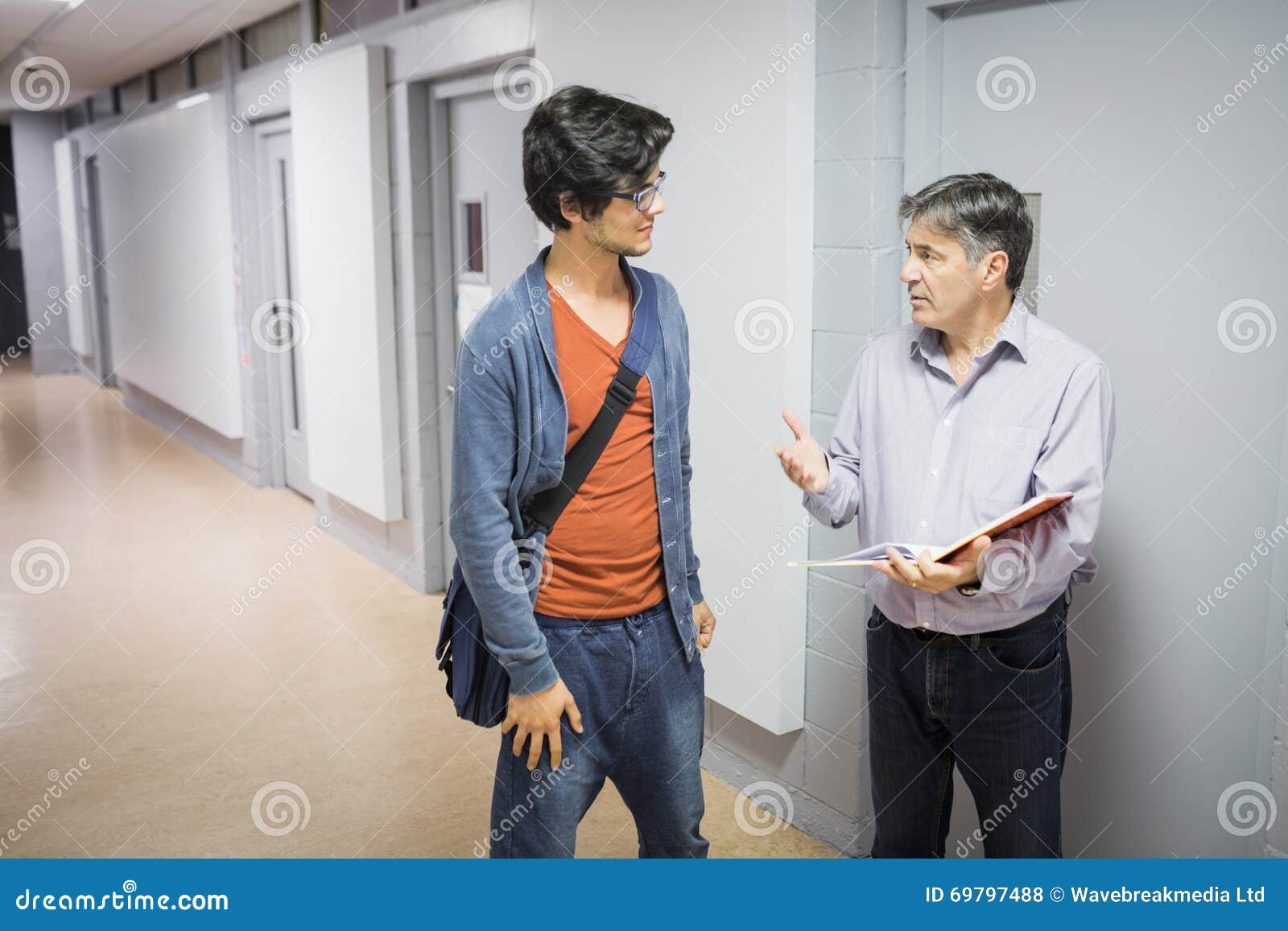 Professor with Notebook Talking To a Student Stock Photo - Image of ...