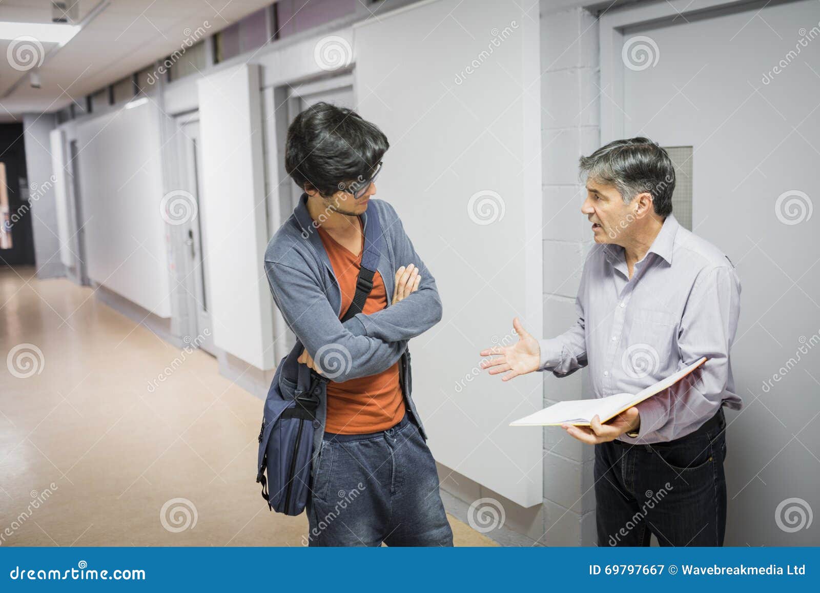 Professor with Notebook Talking To Student Stock Image - Image of ...