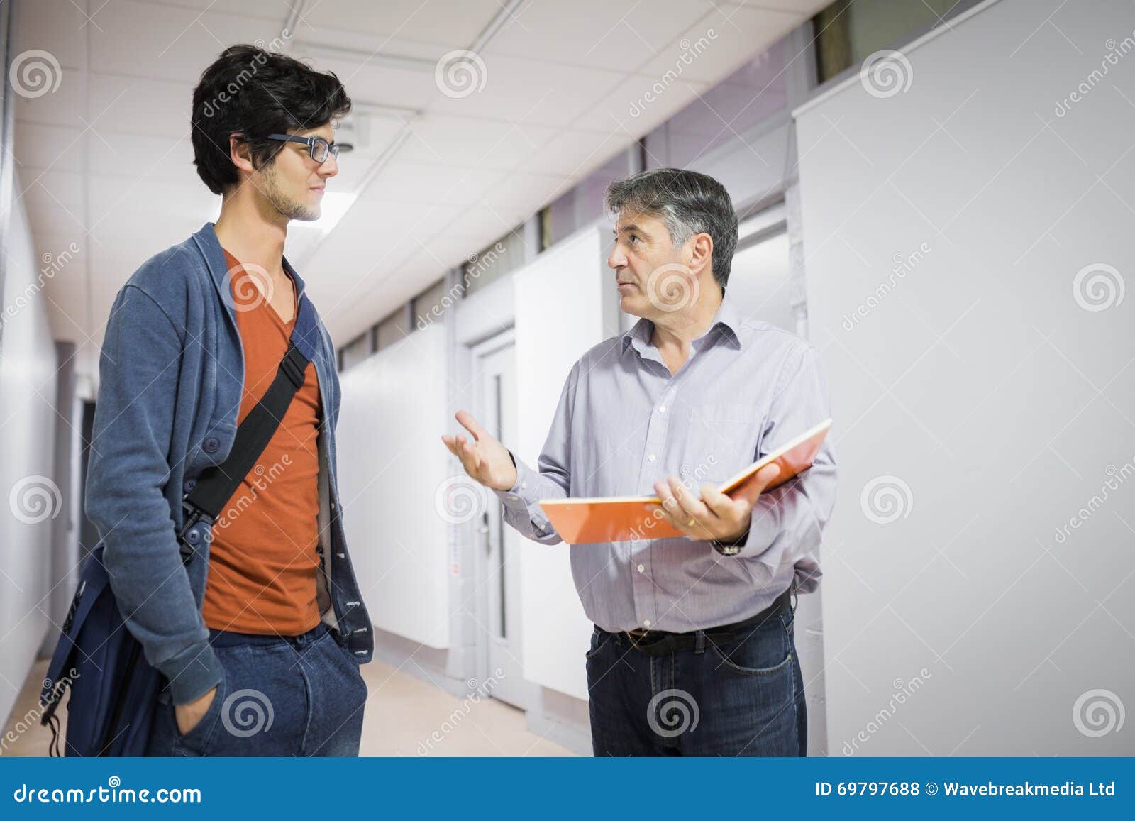 Professor with Notebook Talking To a Student Stock Photo - Image of ...