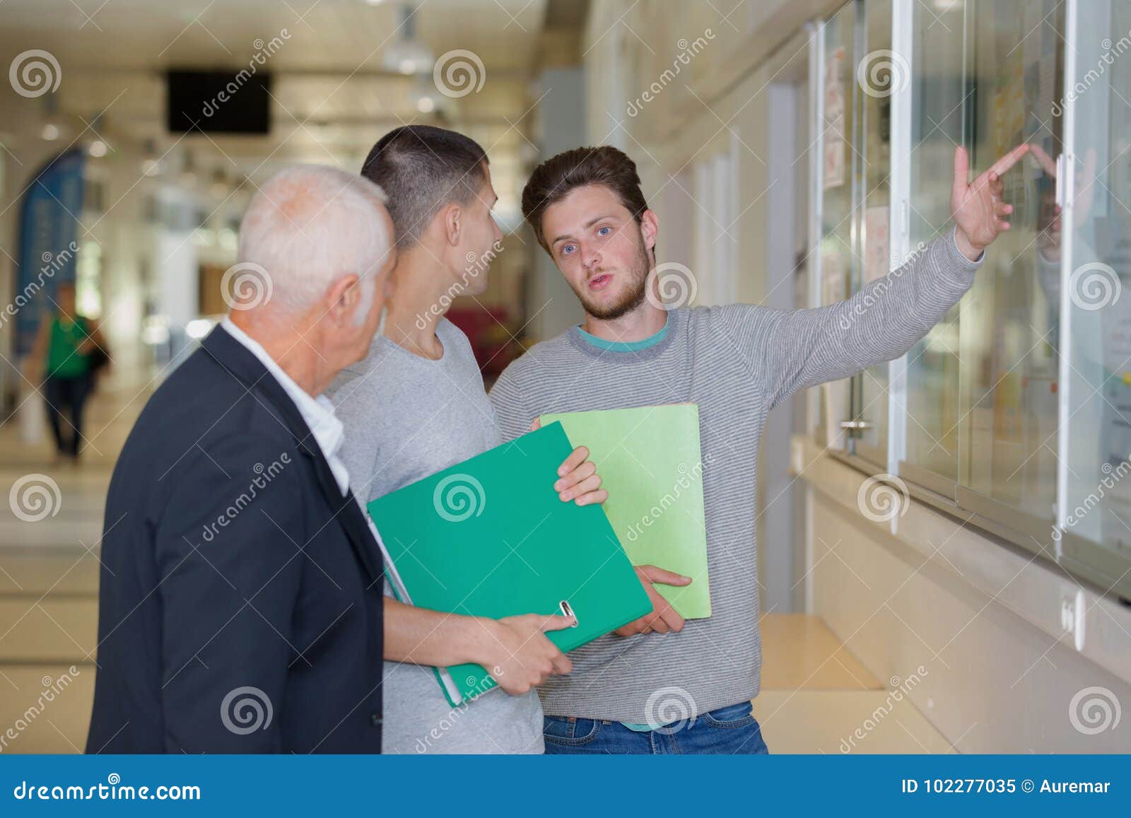 Professor with Notebook Talking To Student in Corridor Stock Image ...