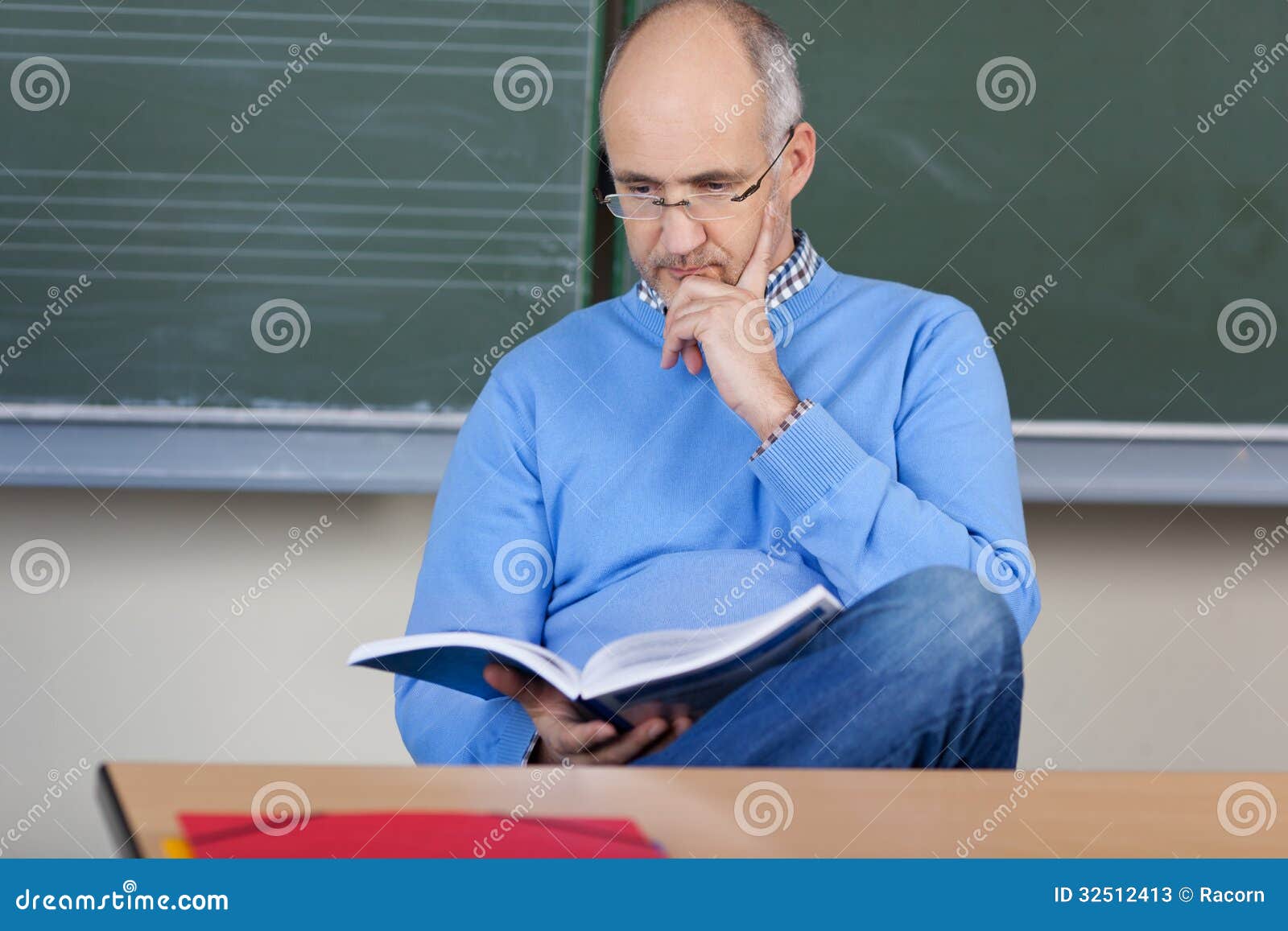 Professor Reading Book at Desk in Classroom Stock Image - Image of ...