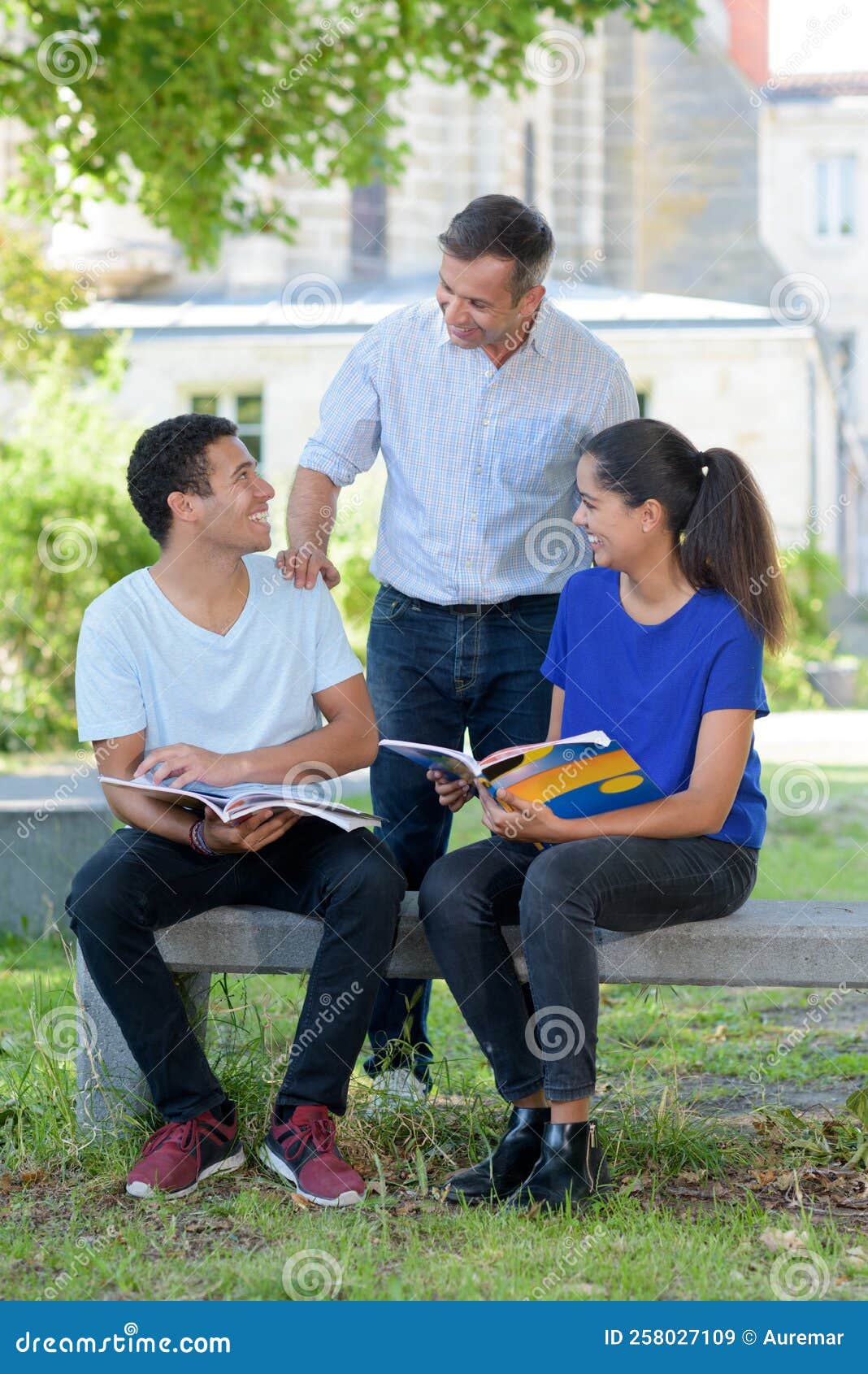 Professor Saying Hello To Students Reviewing on Bench Stock Image ...