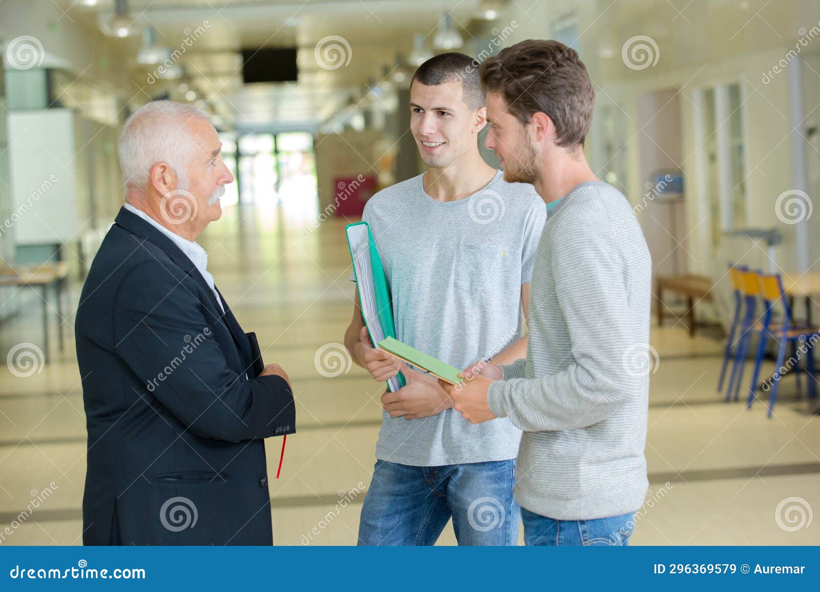 Professor Talking To Students in School Corridor Stock Image - Image of ...
