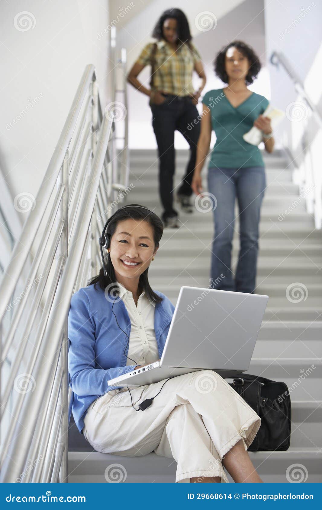 Professor Using Laptop while Students Walking Down Staircase Stock ...