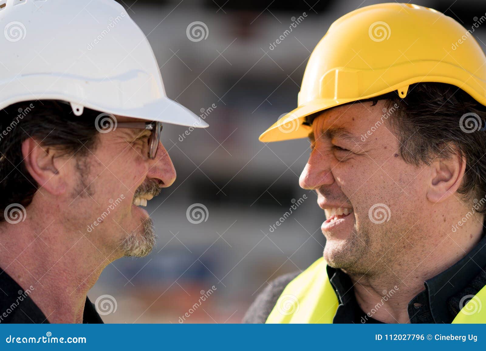 Close Up of Two Smiling Construction Workers Looking at Each Other ...