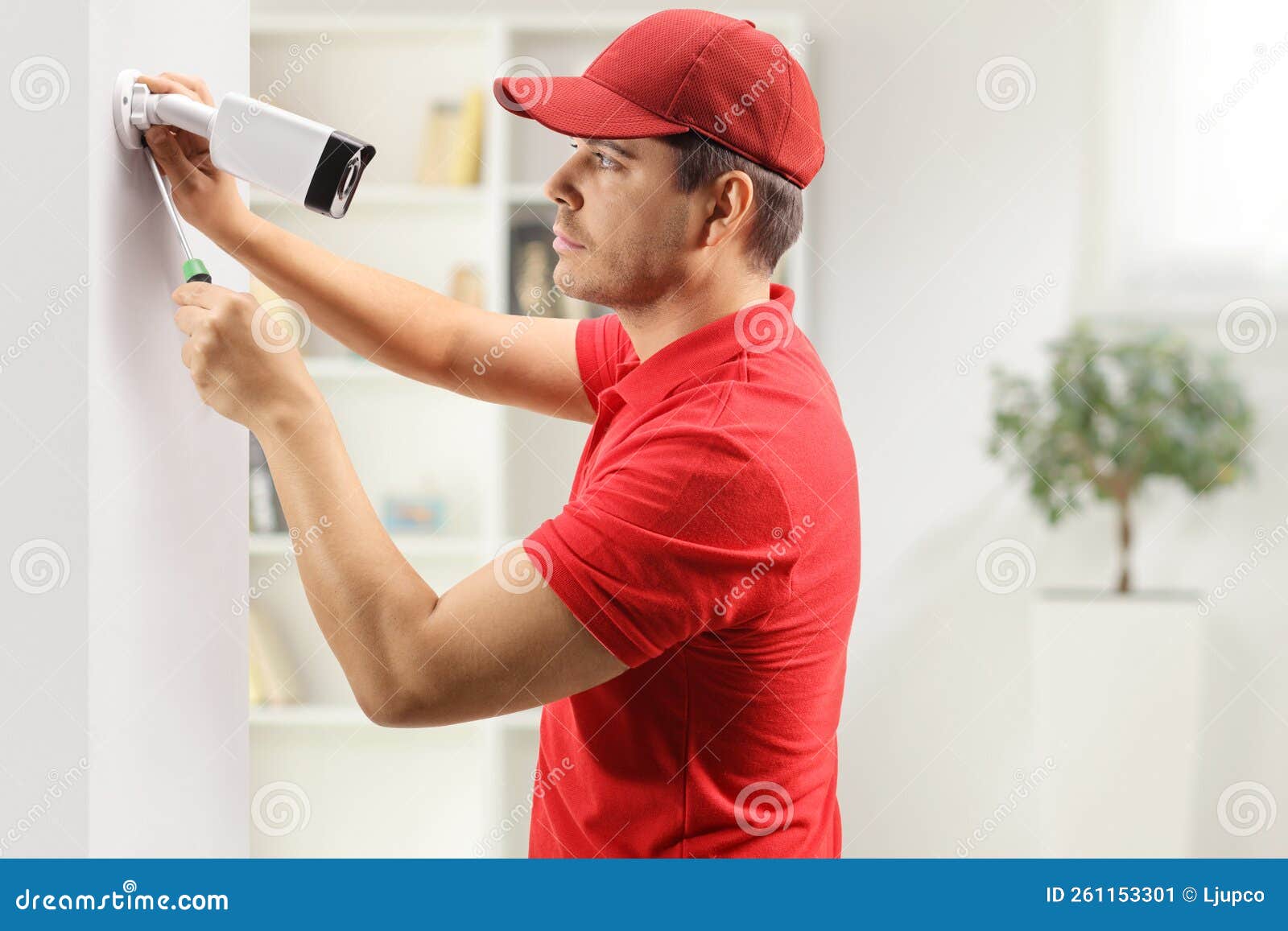 Young Man Installing a Security Camera on a Wall in a Room Stock Image ...