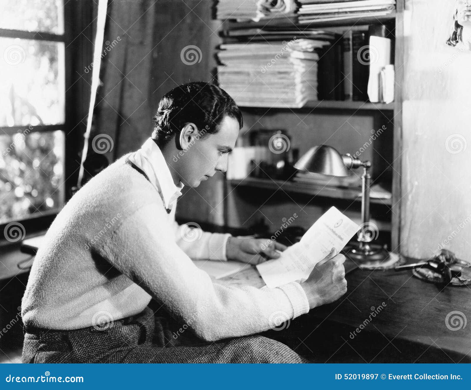 Profile of a Young Man Reading a Paper at His Desk Stock Image - Image ...