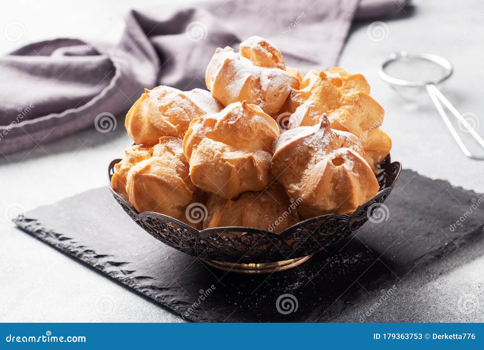 Profiteroles with Custard and Powdered Sugar on a Plate. Concrete Grey ...