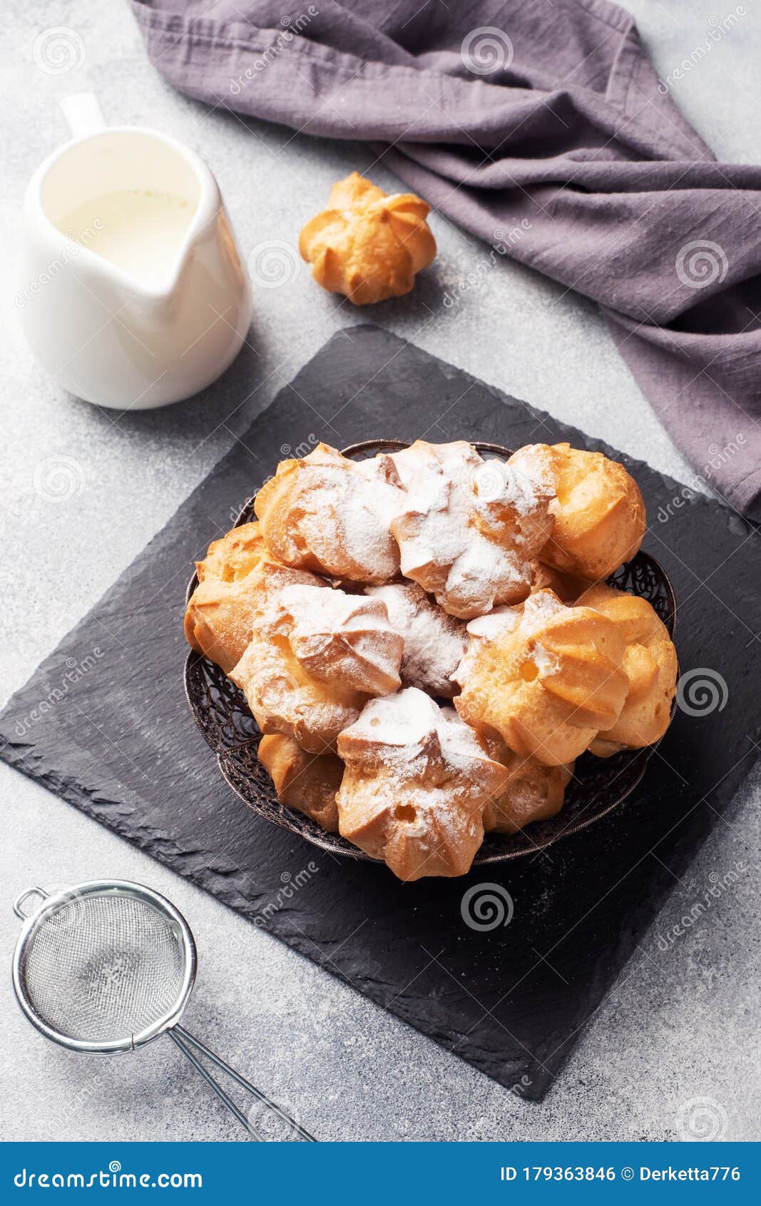 Profiteroles with Custard and Powdered Sugar on a Plate. Concrete Grey ...