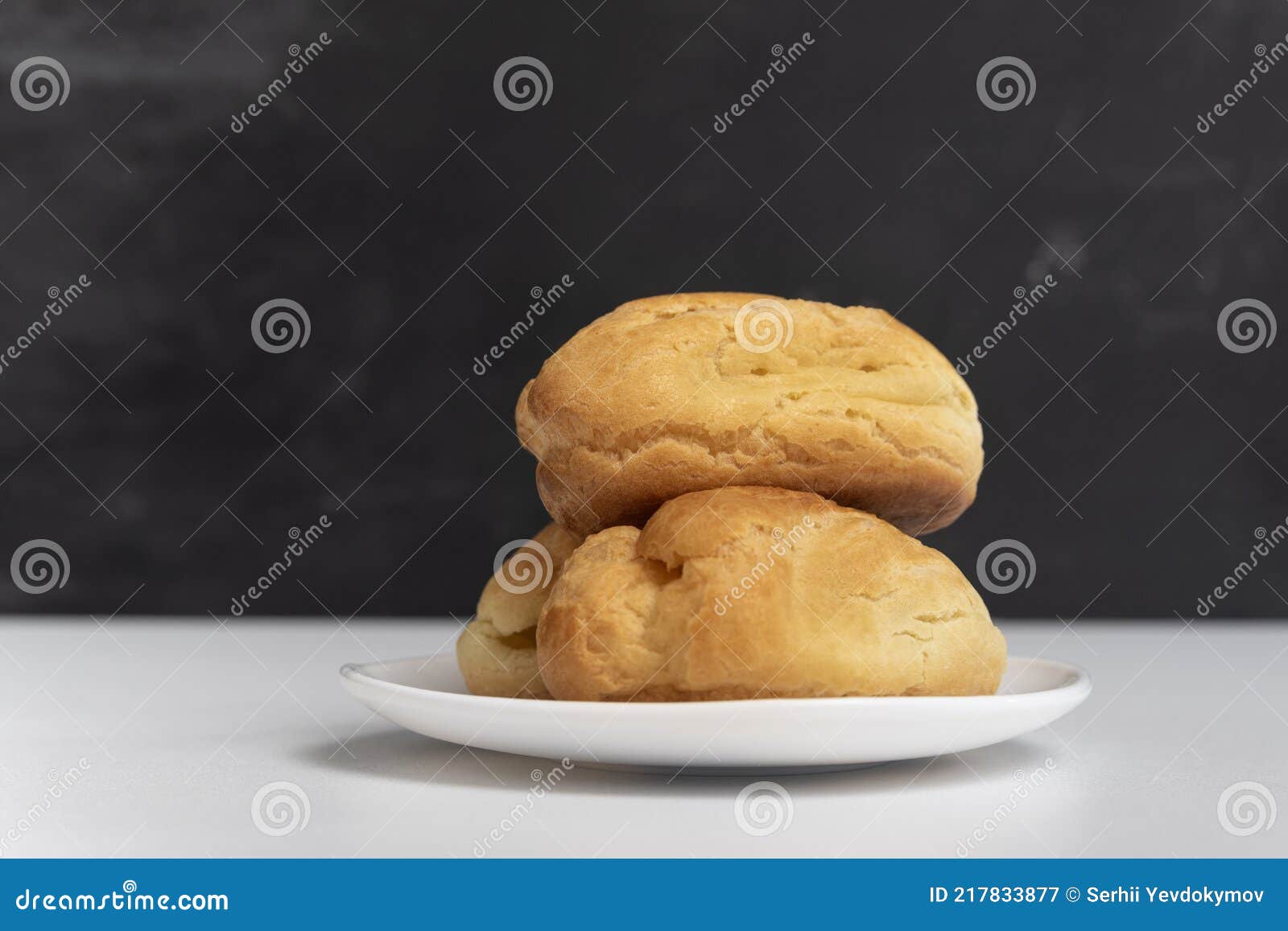 Profiteroles on White Plate. Homemade Puffs, Popovers and Eclairs Stock ...
