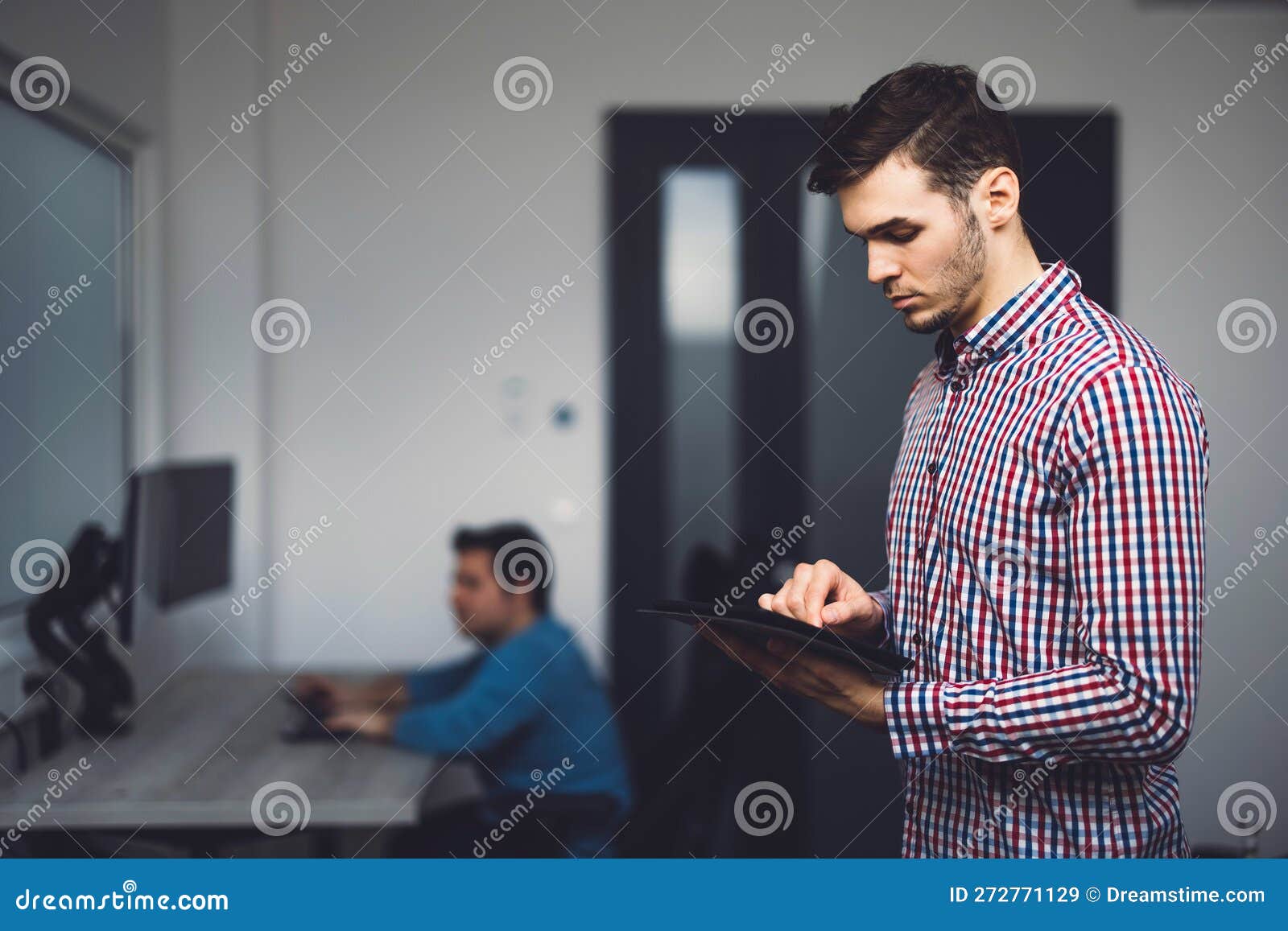 Side View of Young Programmer Standing in the Office Looking Down at ...