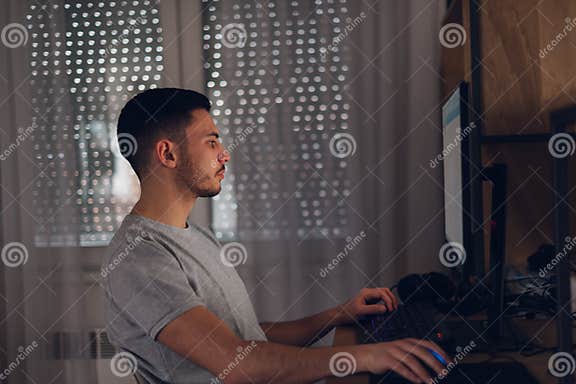 Programmer Working on His Computer at Home while the Screen Light ...