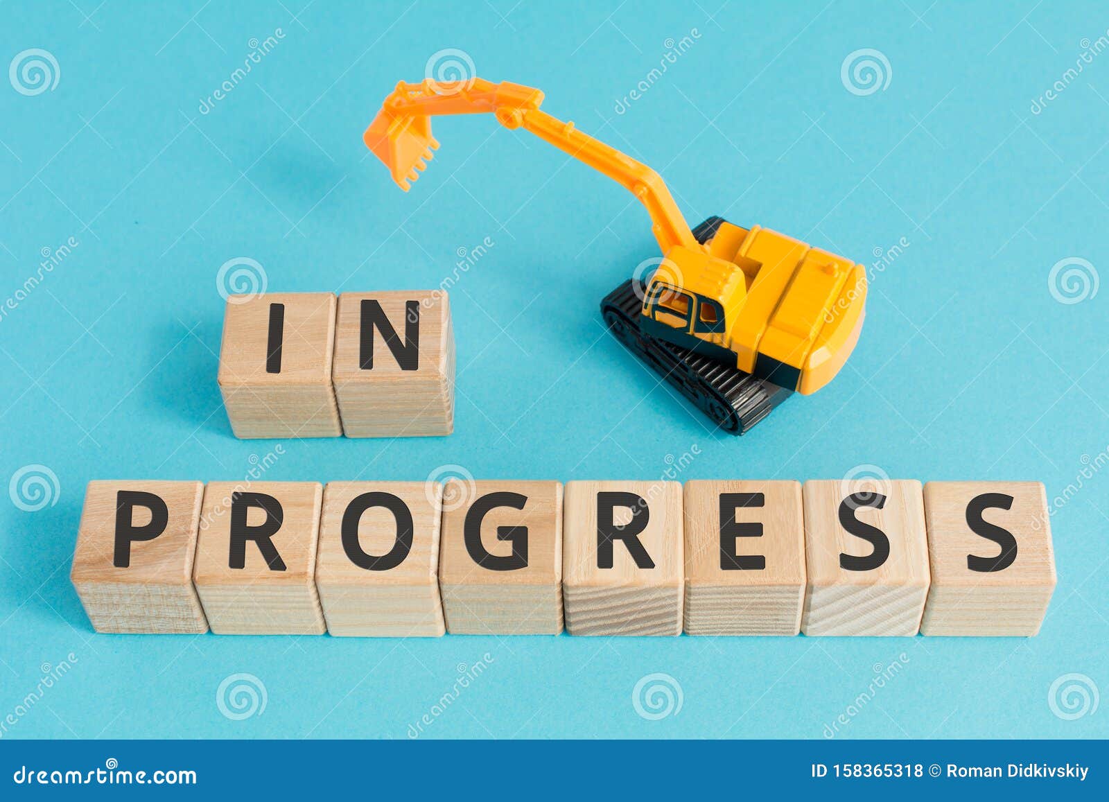 In Progress Wooden Cubes Letters Stock Photo - Image of excavator, blue ...