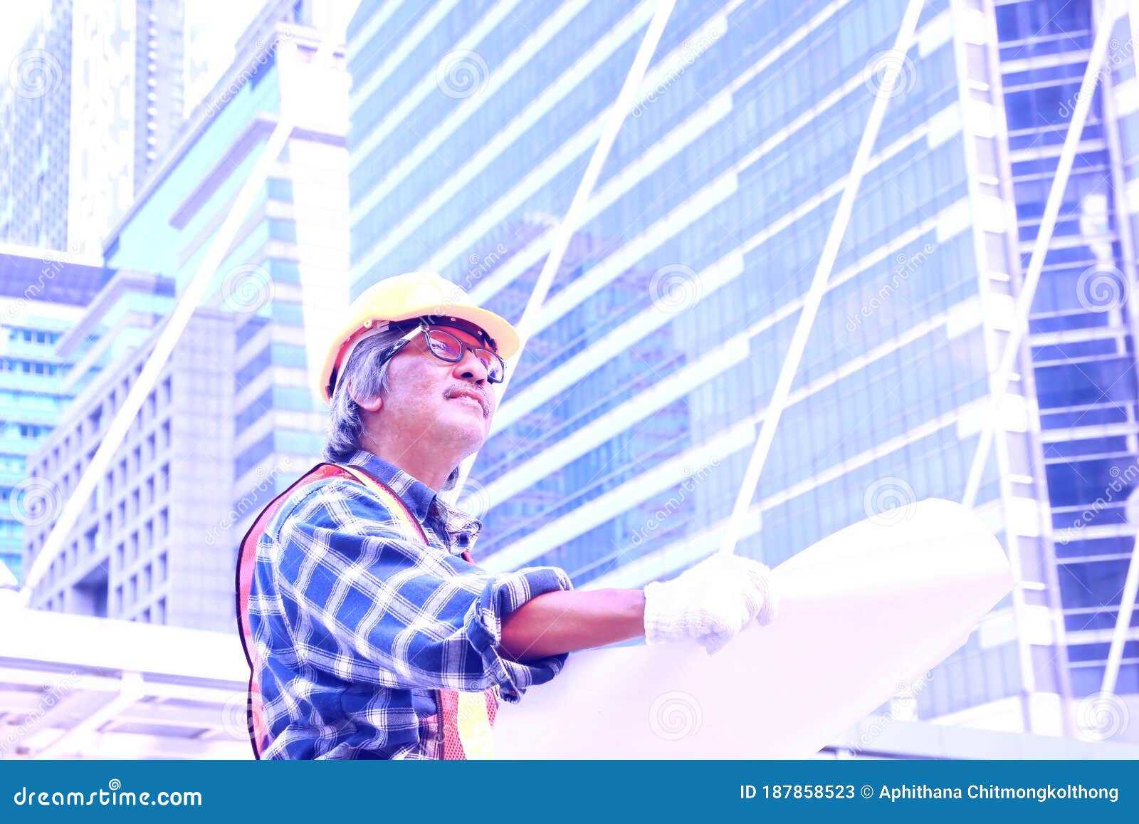 The Project Engineer Holding Plan in Hand Looking To the Building in ...