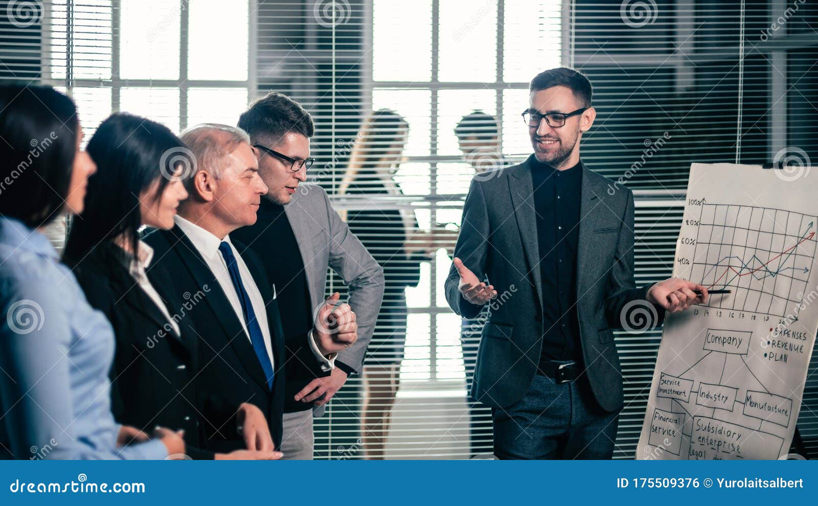Project Manager Pointing To a Flipchart with a Schedule Stock Photo ...