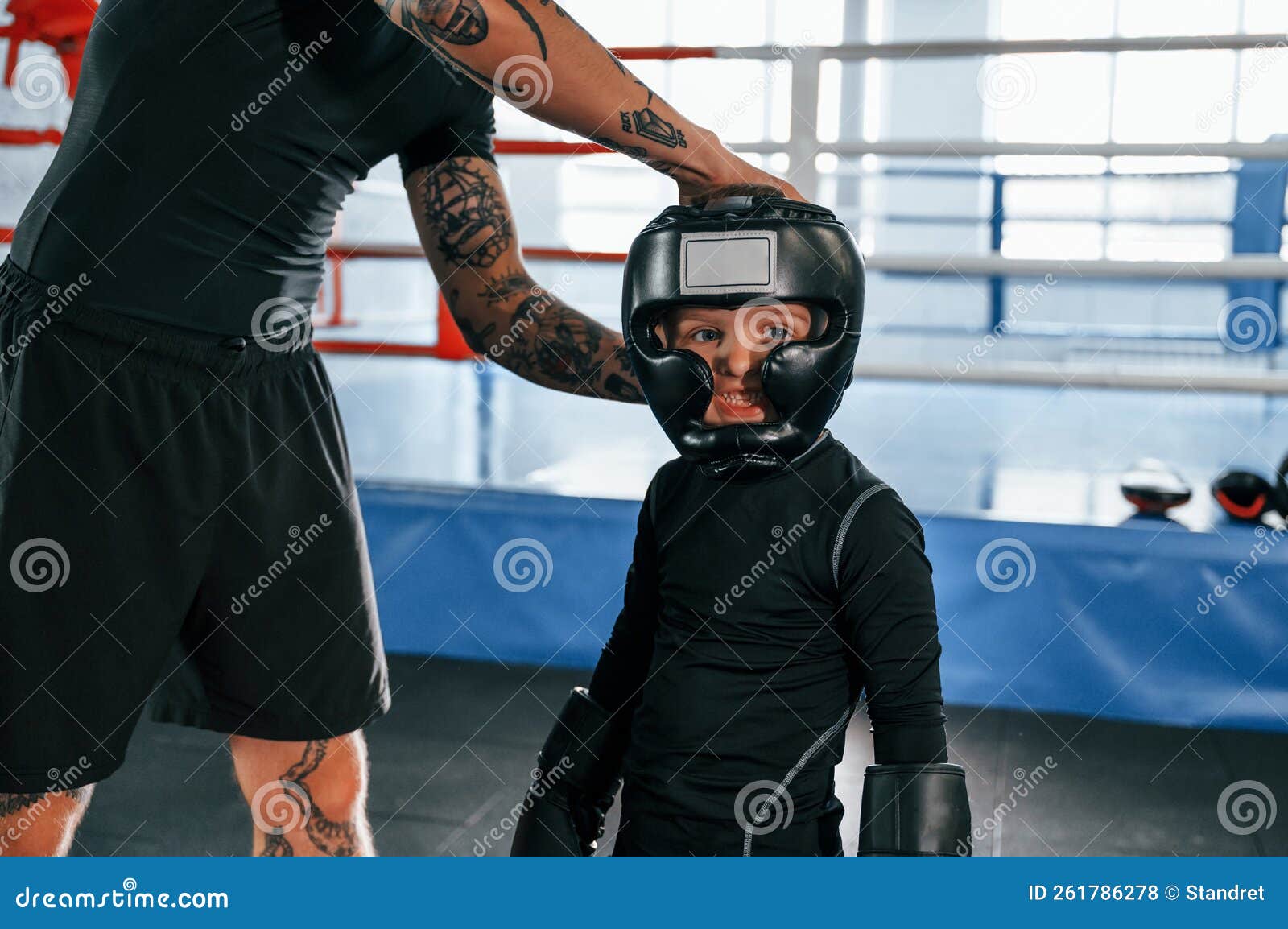 In Protective Helmet. Coach is Teaching the Boy Box Techniques Indoors ...