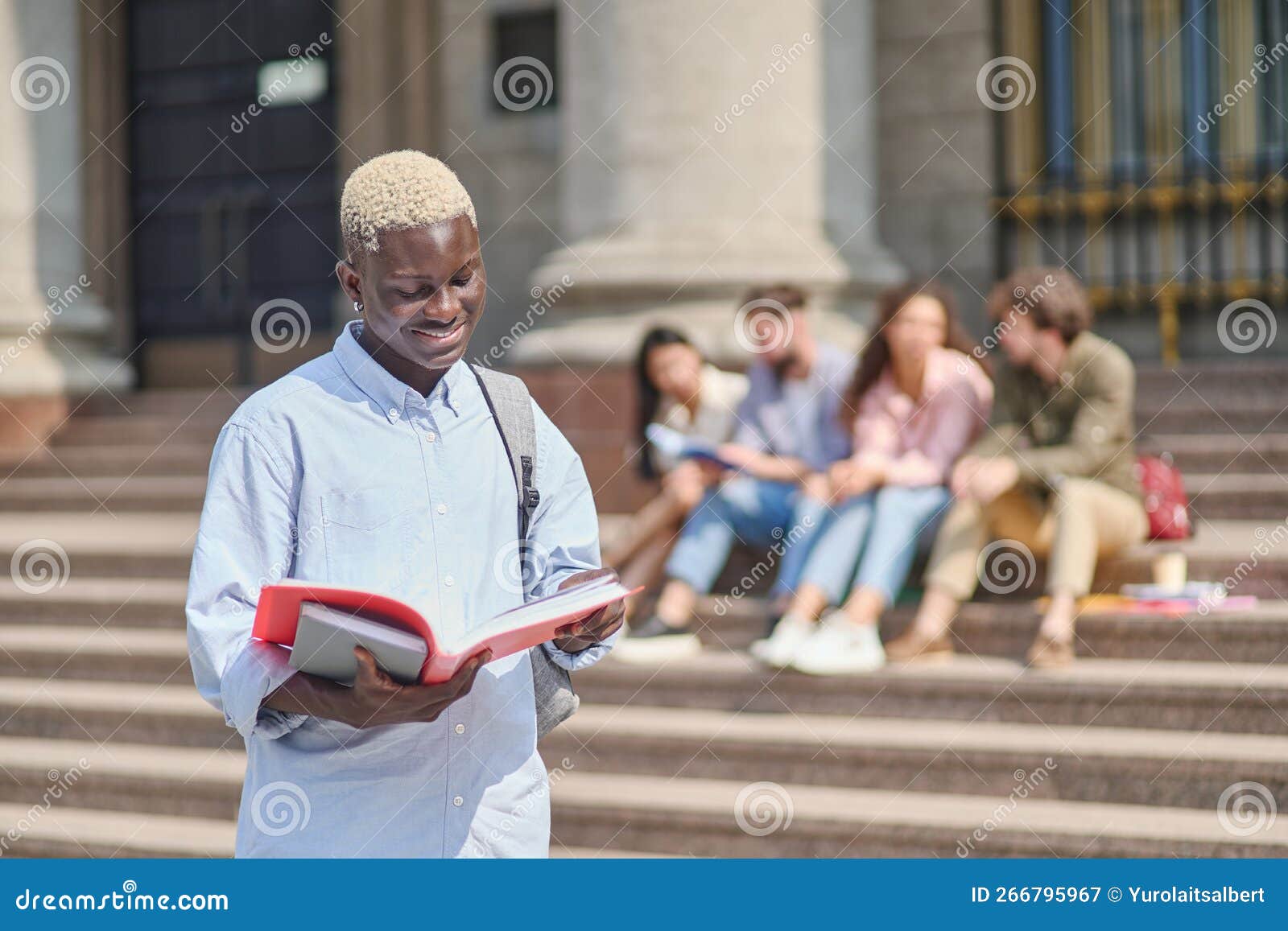 Proud Student with a Textbook Standing in Front of the University ...