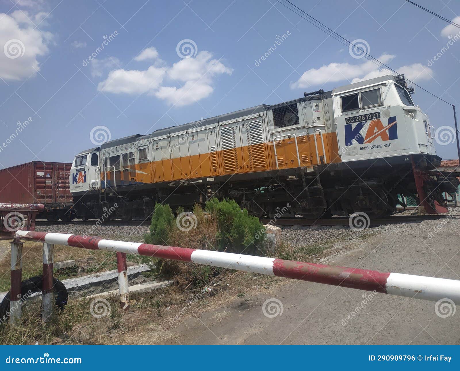 PT KAI Container Train Passes at a Railroad Crossing with Gates ...