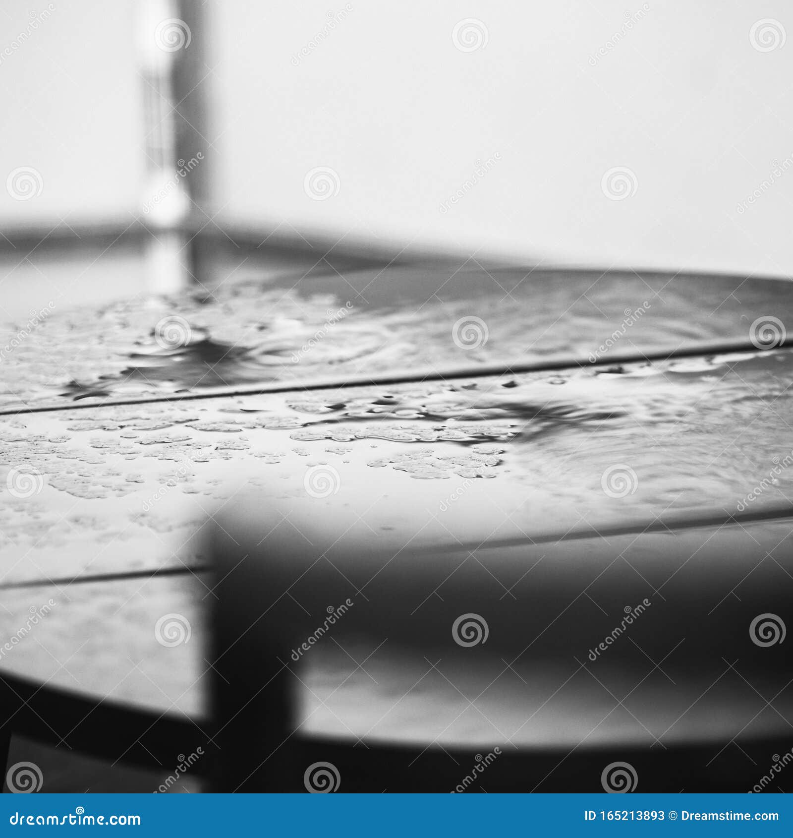 Puddle on a balcony table stock image. Image of colours - 165213893