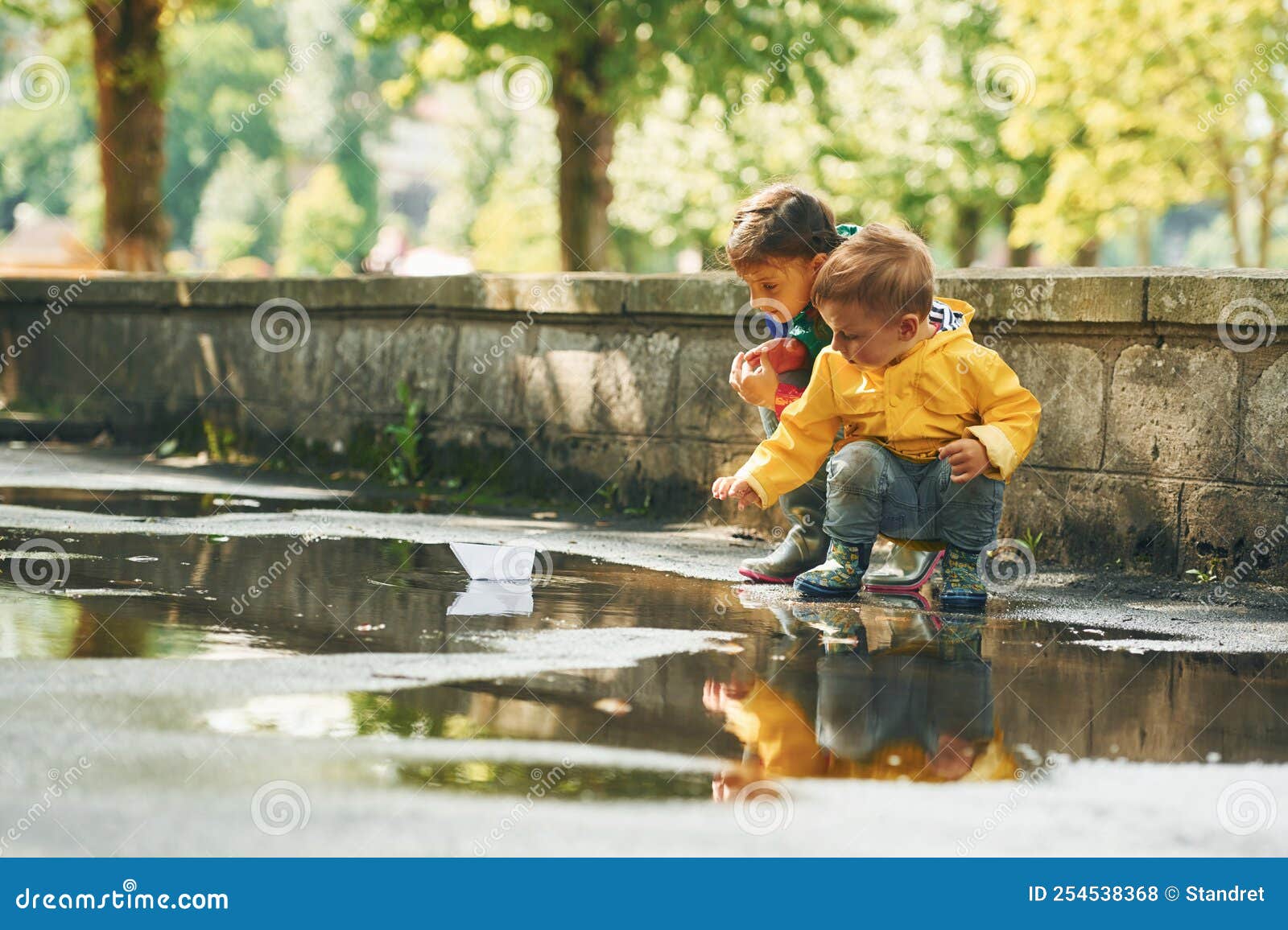 In the Puddle. Kids Having Fun Outdoors in the Park after the Rain ...