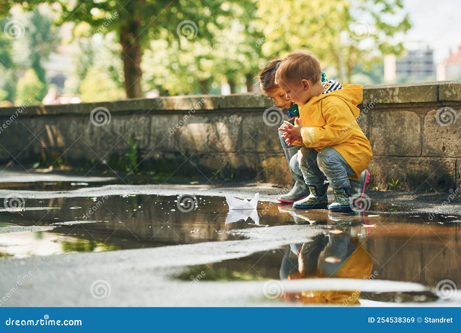 In the Puddle. Kids Having Fun Outdoors in the Park after the Rain ...