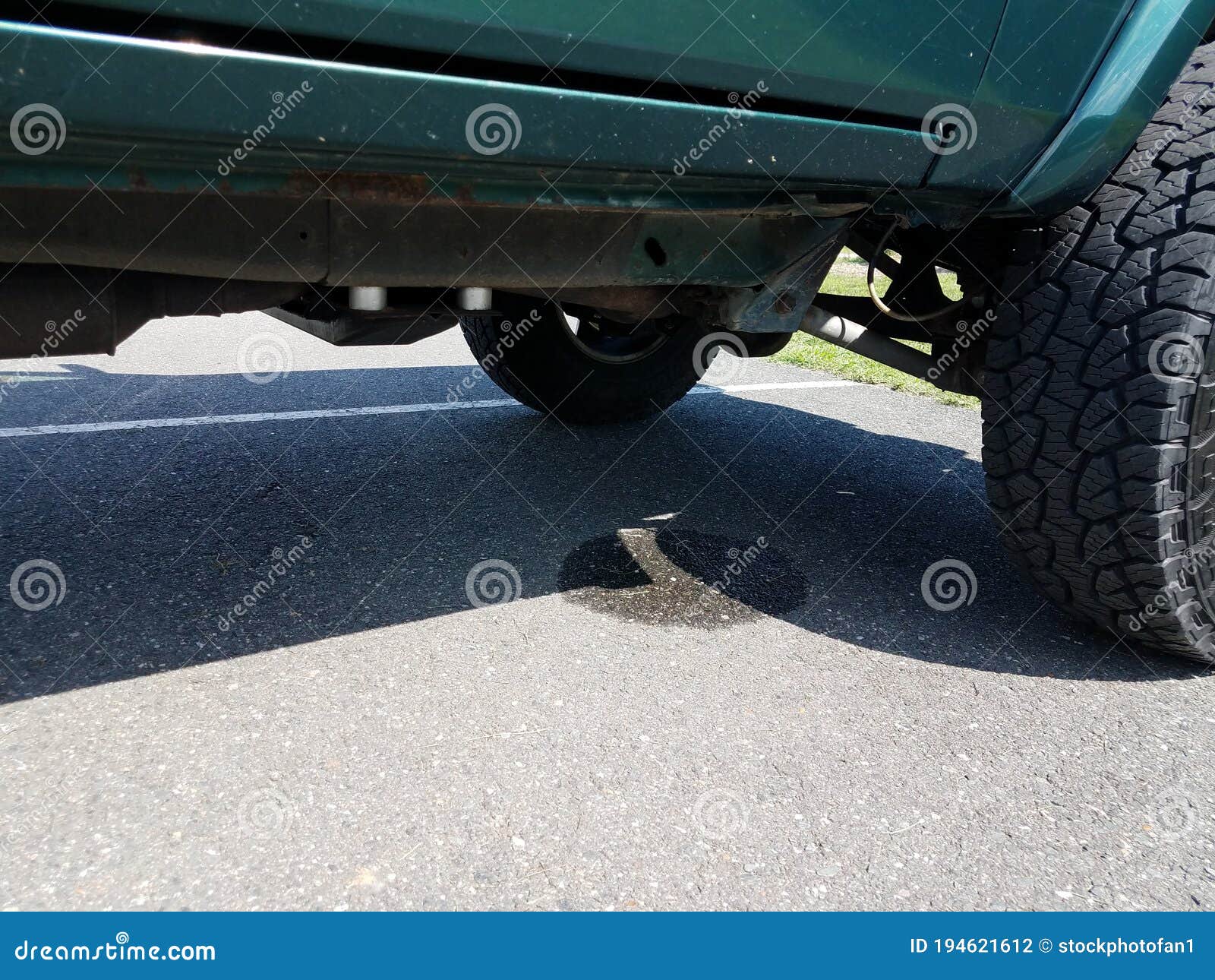 Puddle from Leak Under Green Car or Vehicle Stock Photo - Image of ...