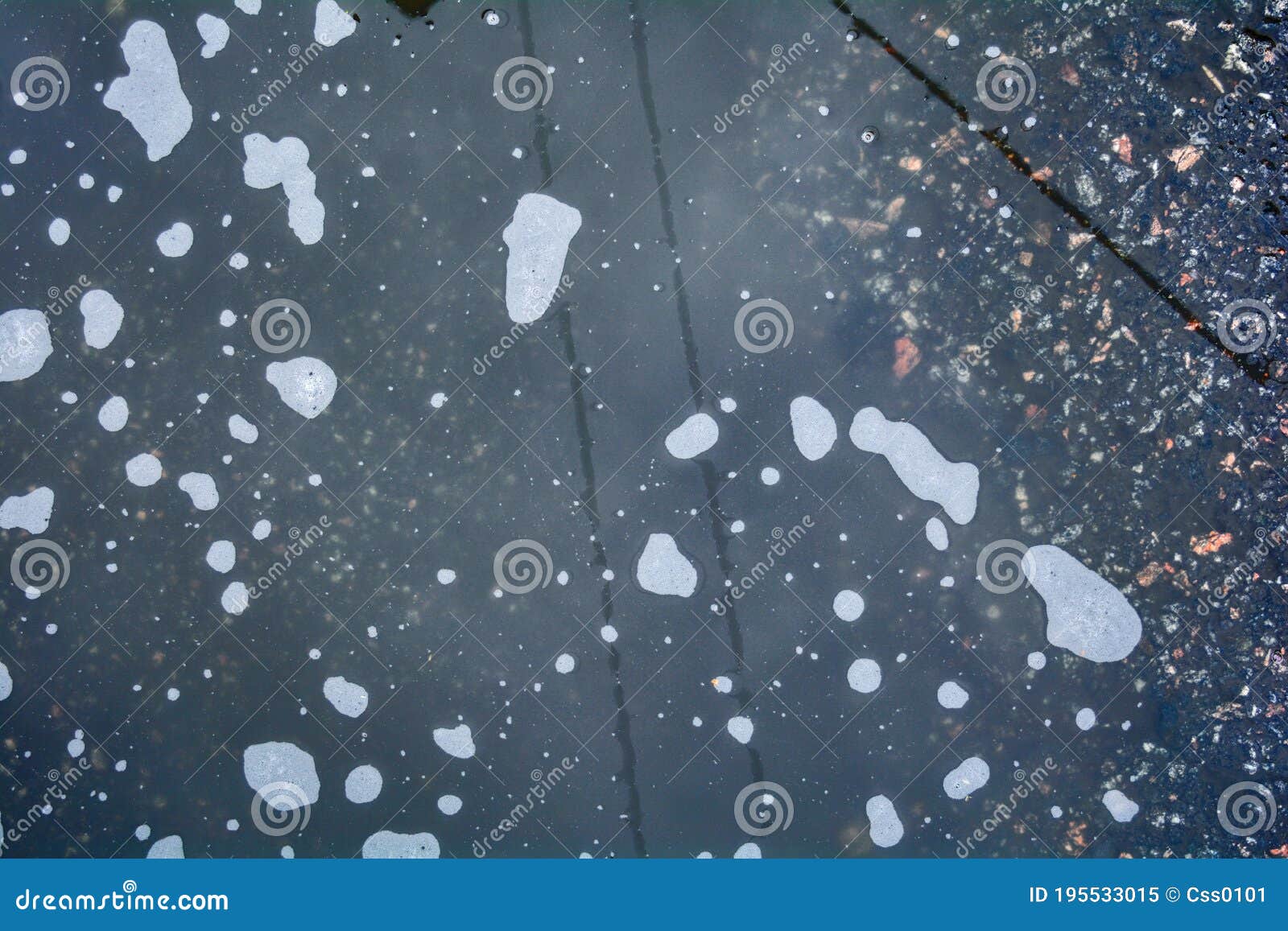 Puddle on the Pavement of a City Road with Spots of White Foam and ...